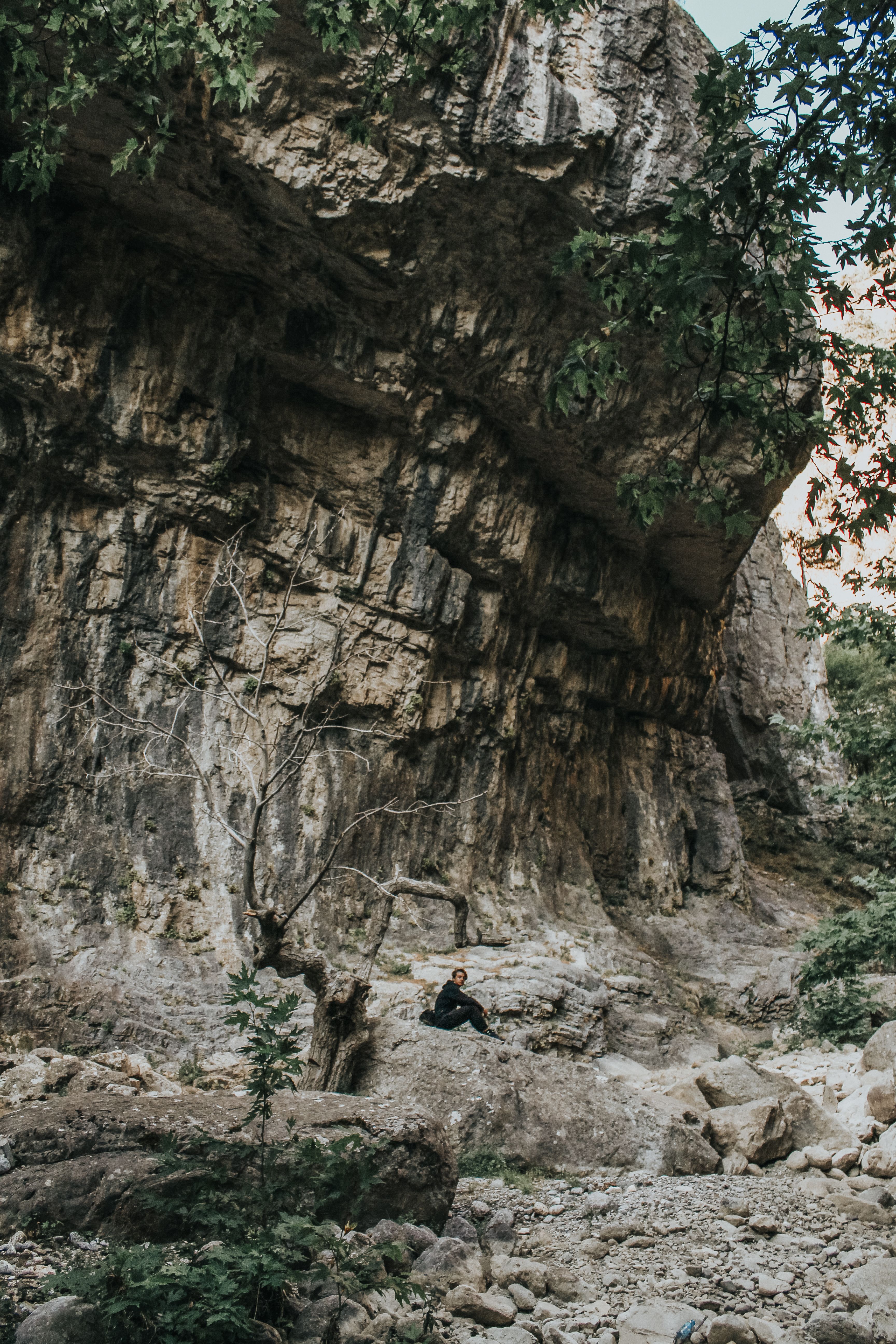 Person Sitting under Rocks · Free Stock Photo