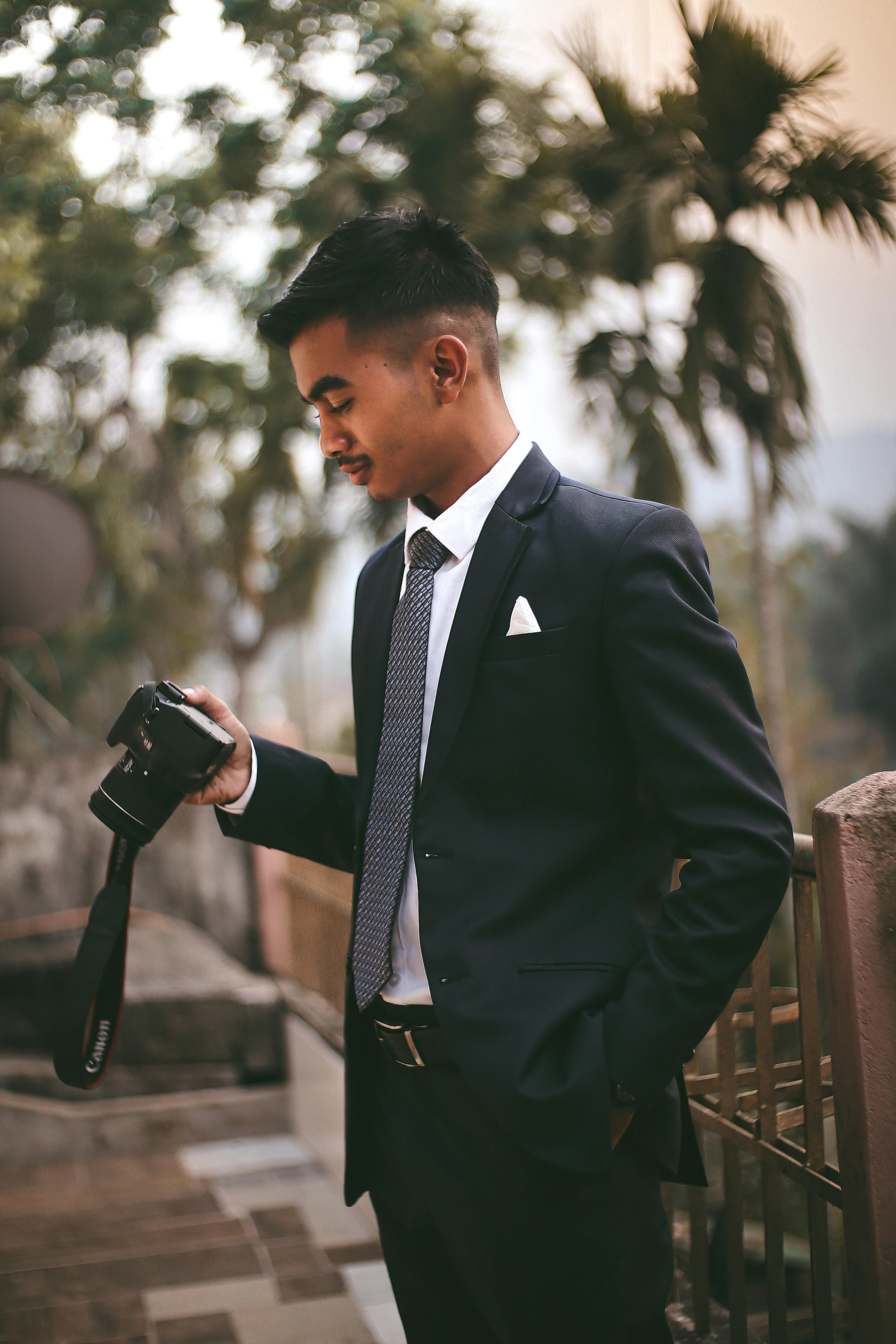 Young Man in a Suit Looking at his Camera · Free Stock Photo