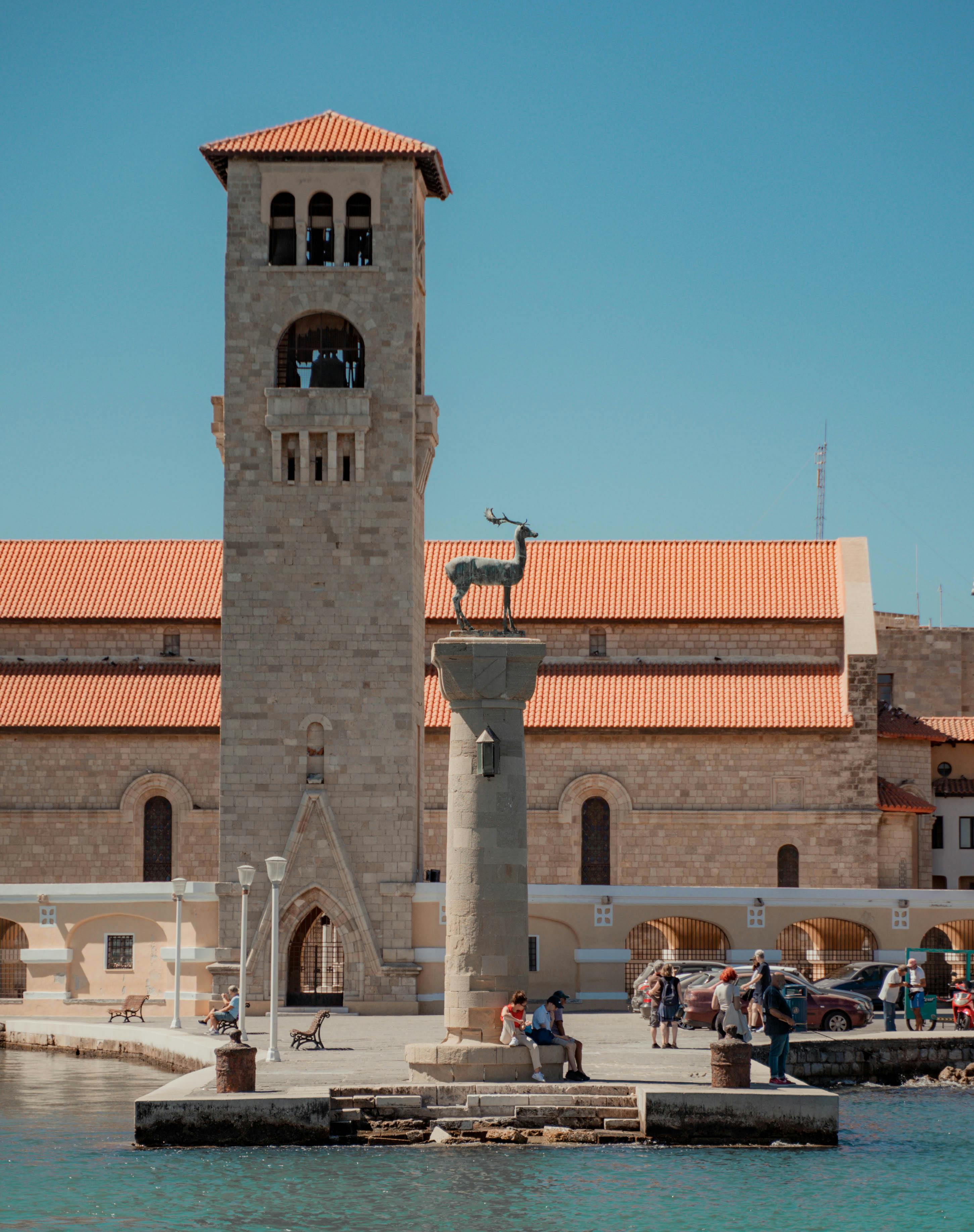 Bell Tower and Monument on Shore on Rhodes · Free Stock Photo