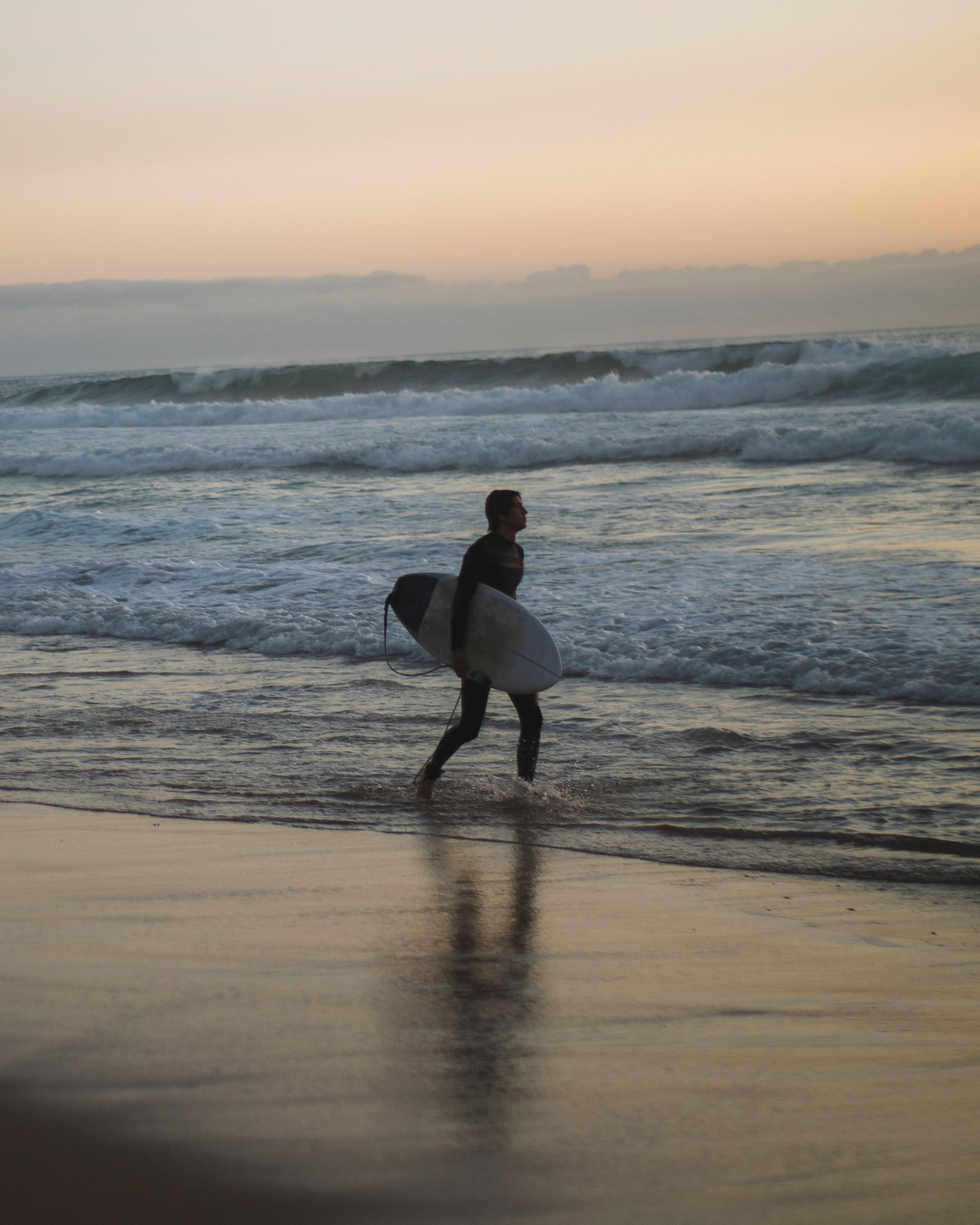 A Surfer on a Beach · Free Stock Photo