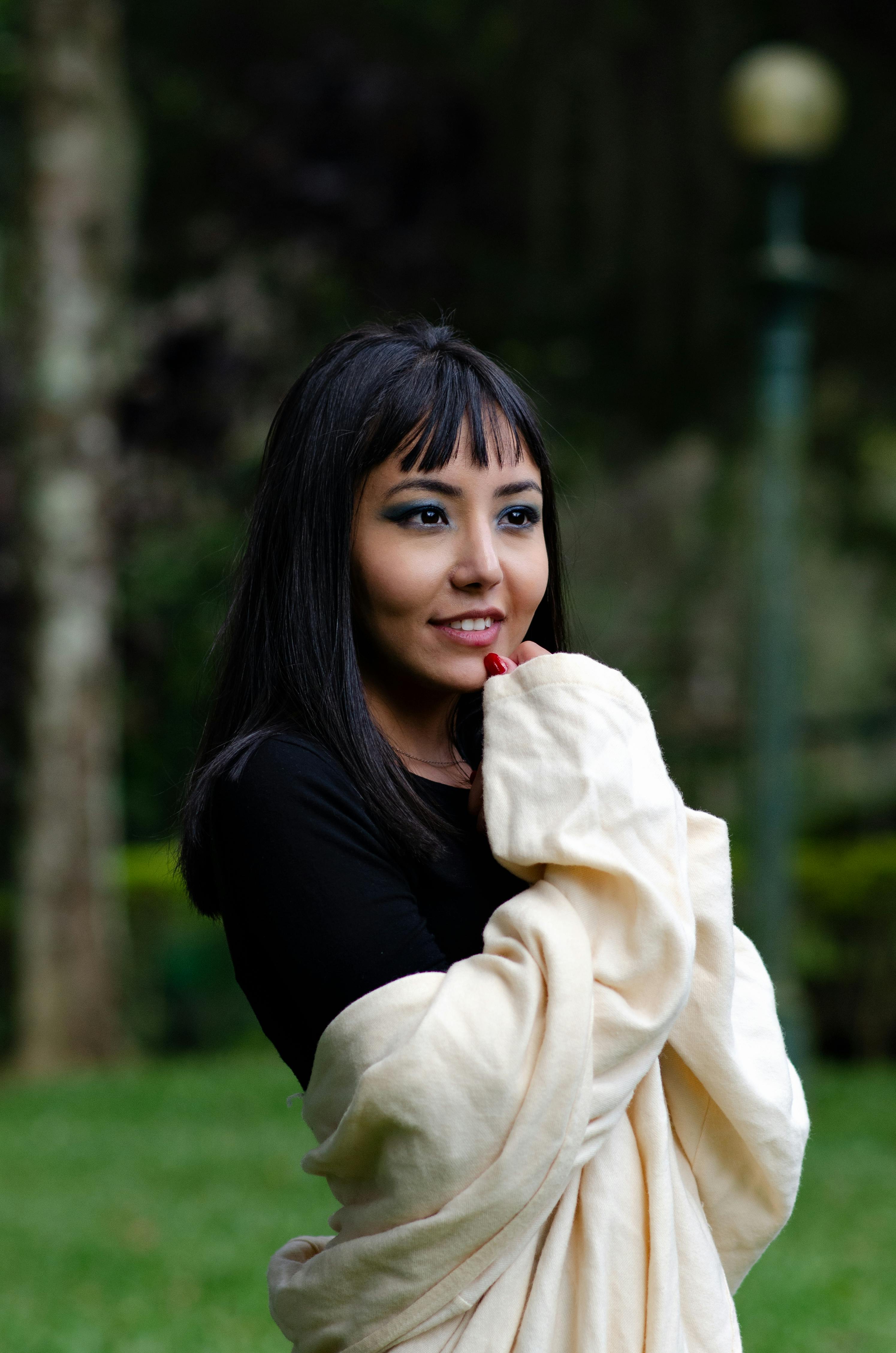 Photo of a Brunette Woman Wearing a Blue Blouse Standing by a Lake ...