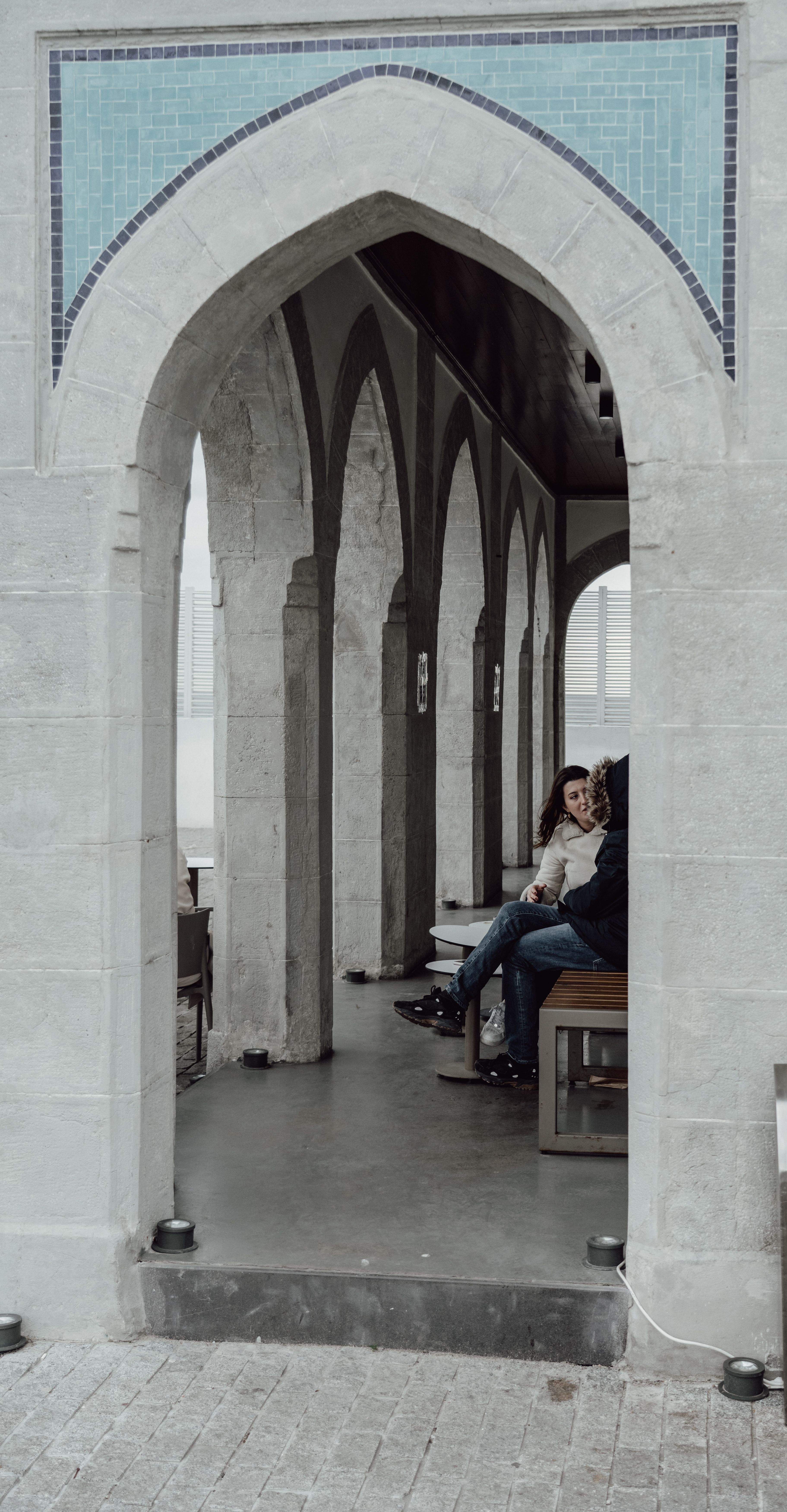 Women Sitting on Bench behind Doorway · Free Stock Photo