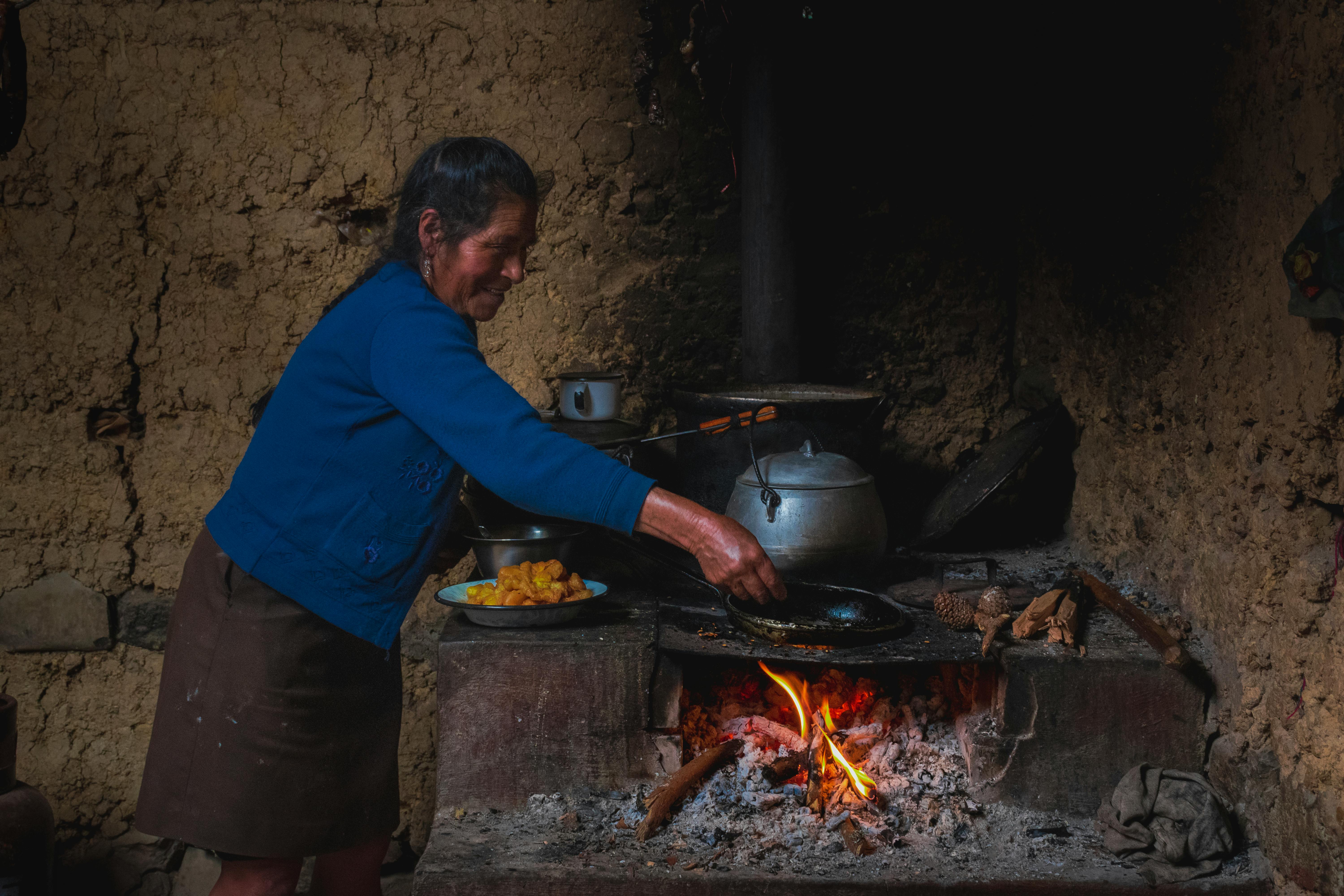 Woman Cooking a Meal over a Traditional Stove in her Kitchen · Free ...