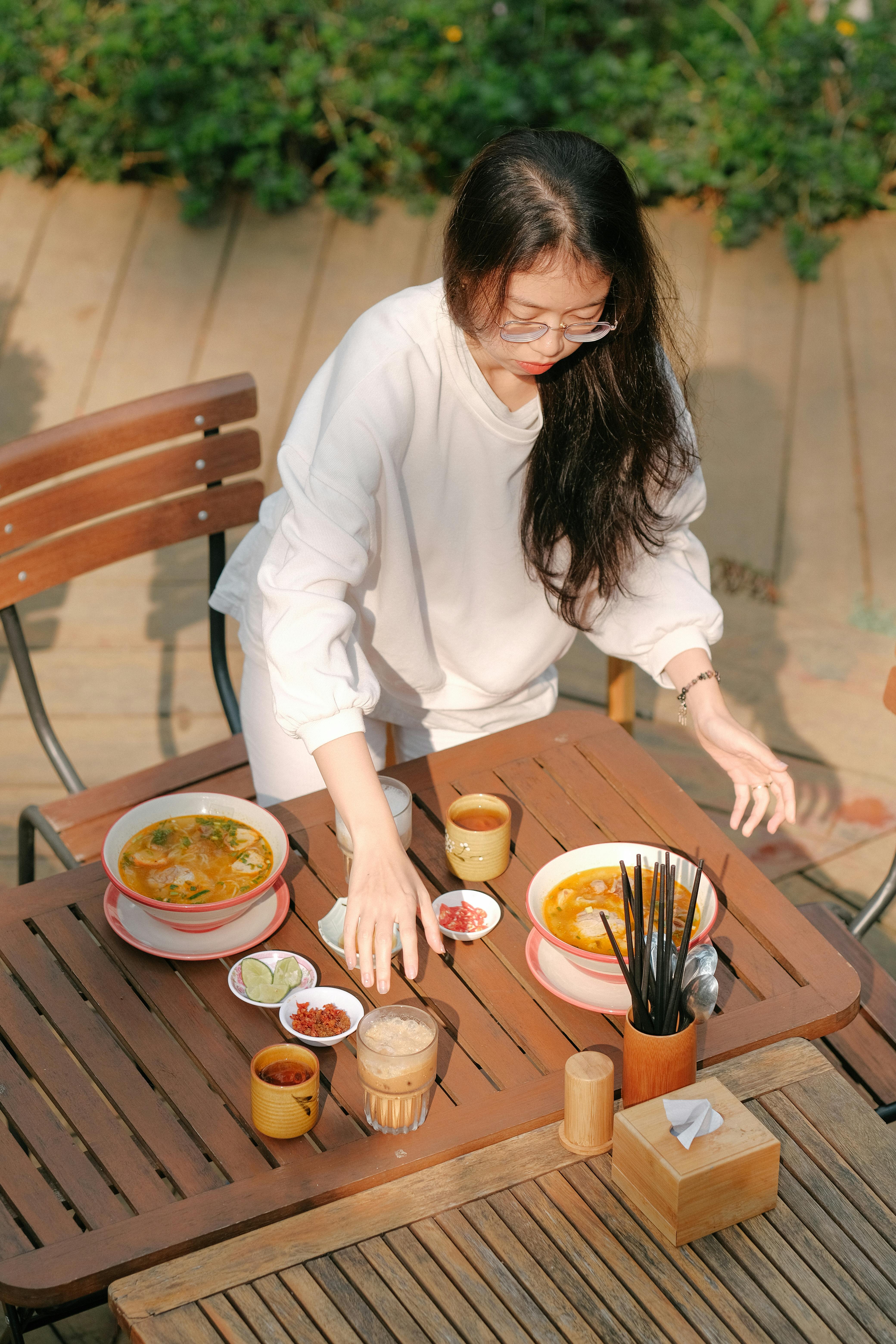 Woman Standing by Table with Food · Free Stock Photo