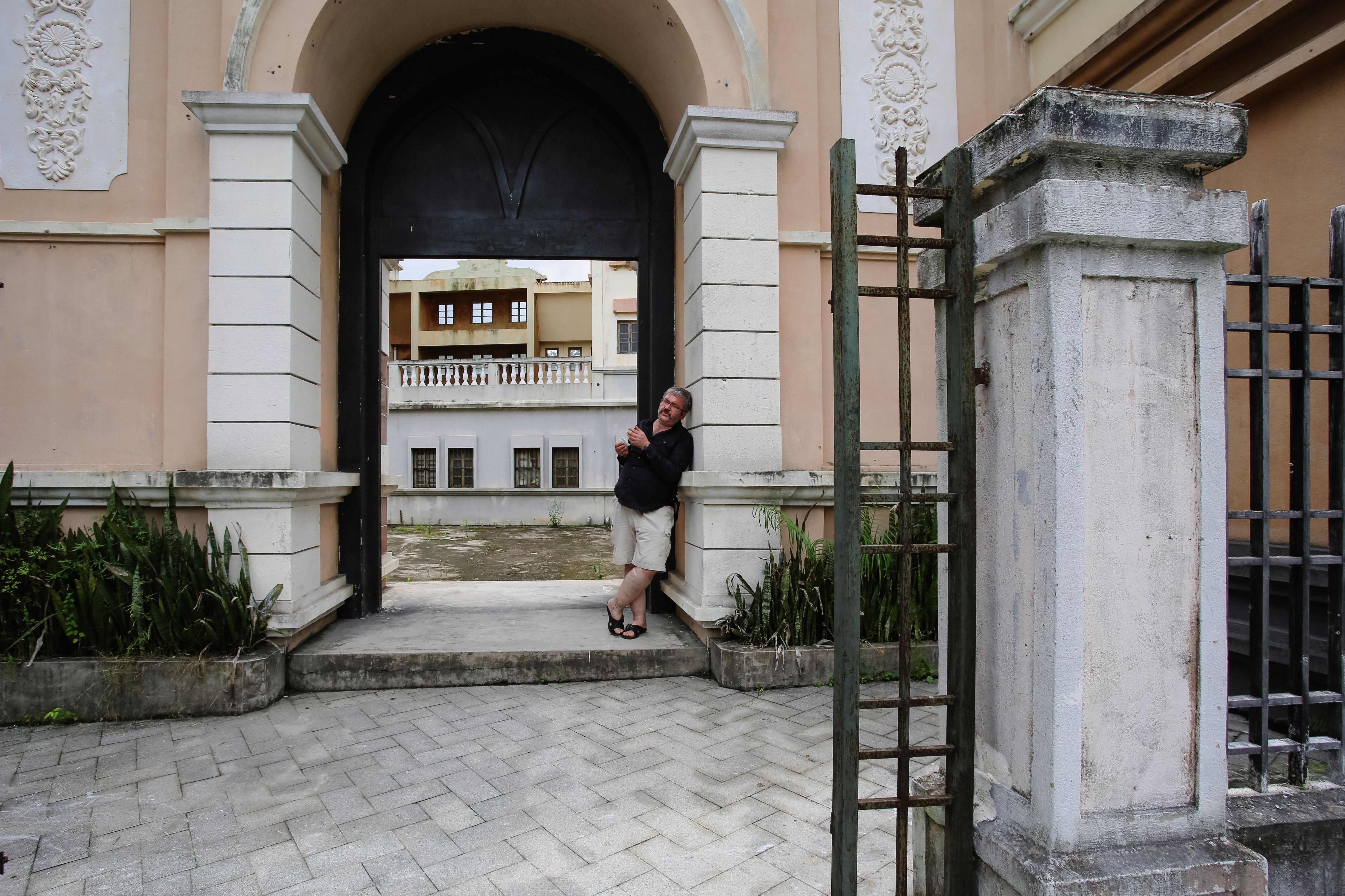 Man Standing and Leaning against the Gate · Free Stock Photo