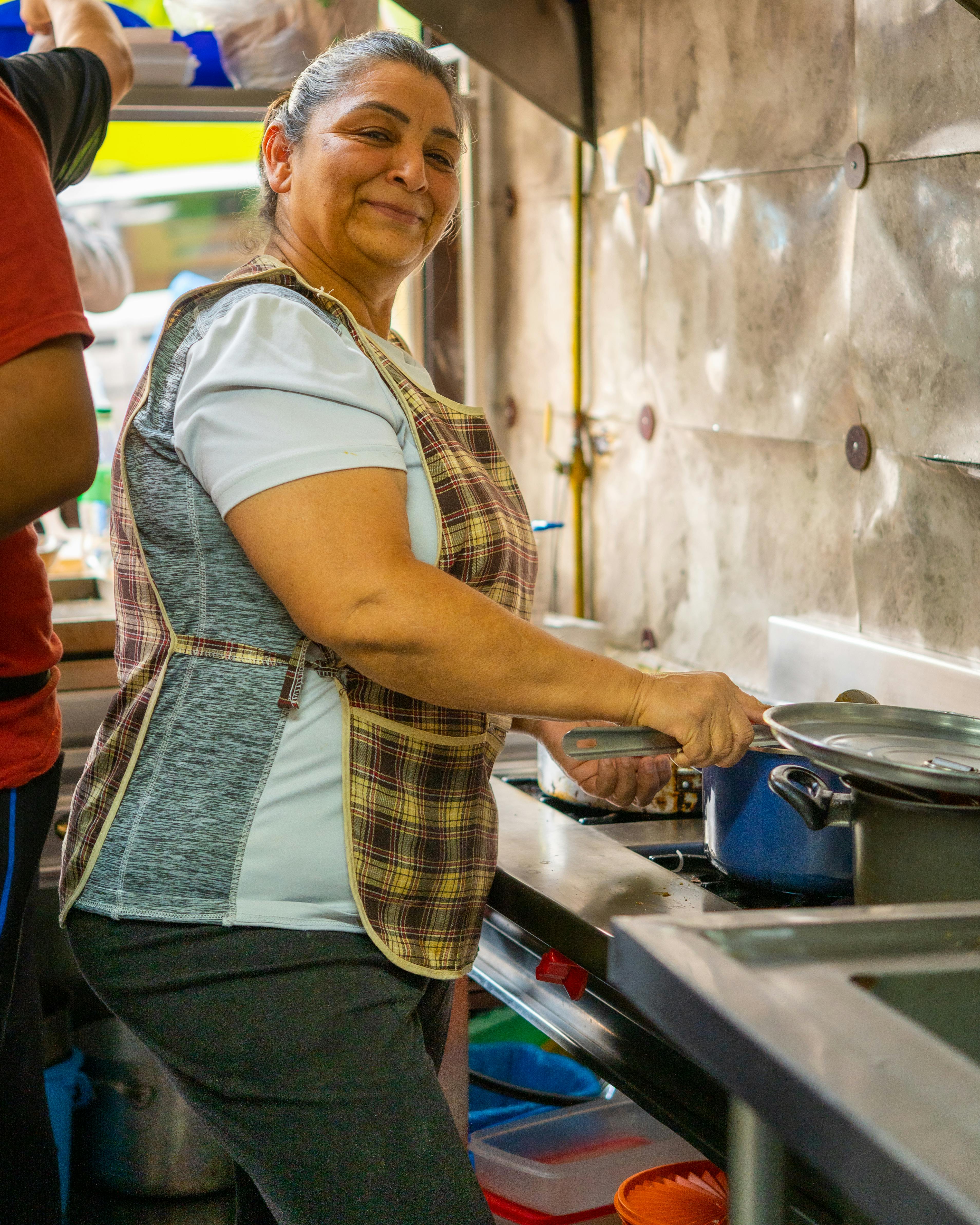 Woman Wearing an Apron Washing Dishes in a Sink · Free Stock Photo
