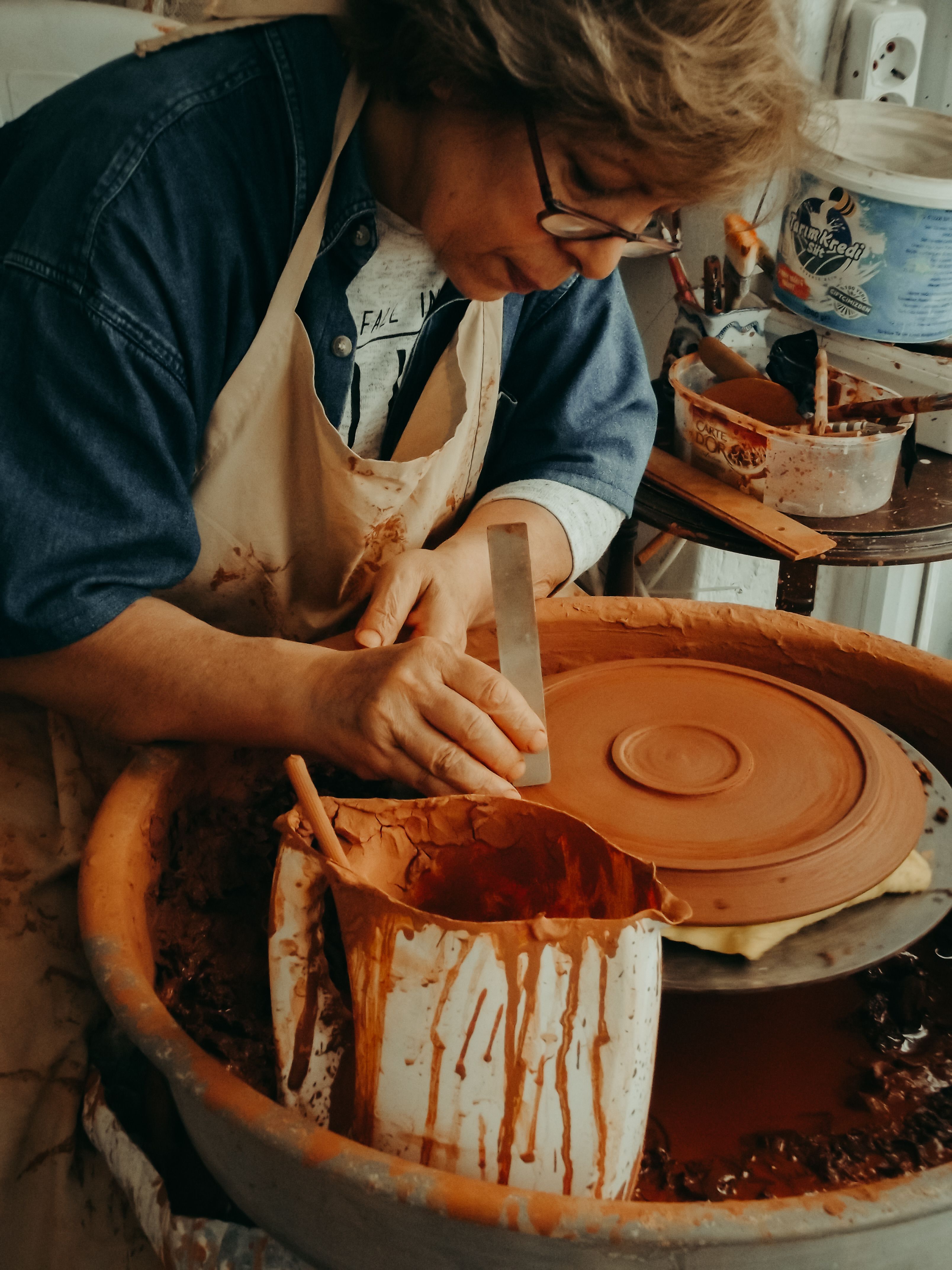 Woman forming clay bowl on pottery wheel · Free Stock Photo