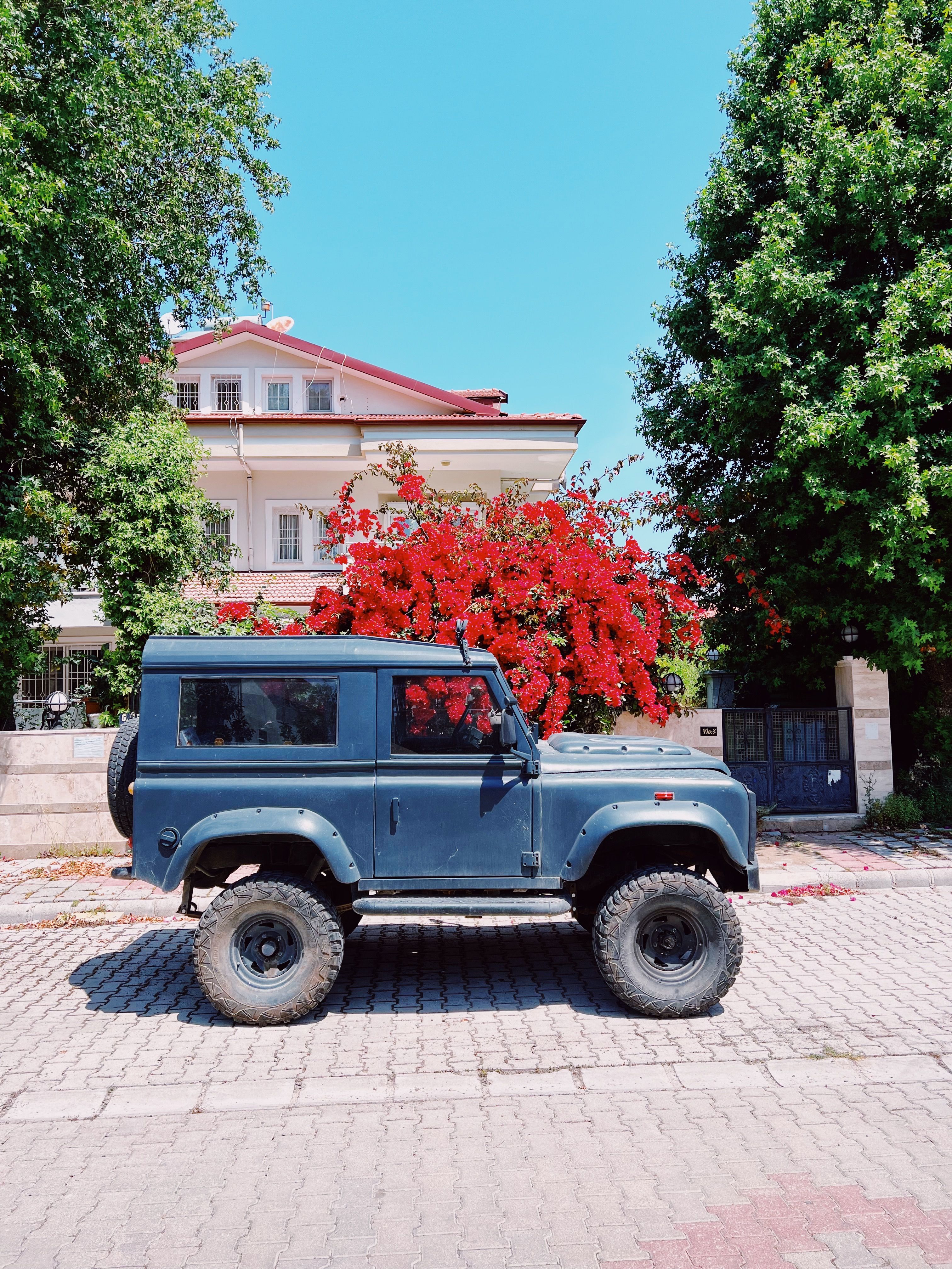 An Old Land Rover Defender Parked near a House · Free Stock Photo
