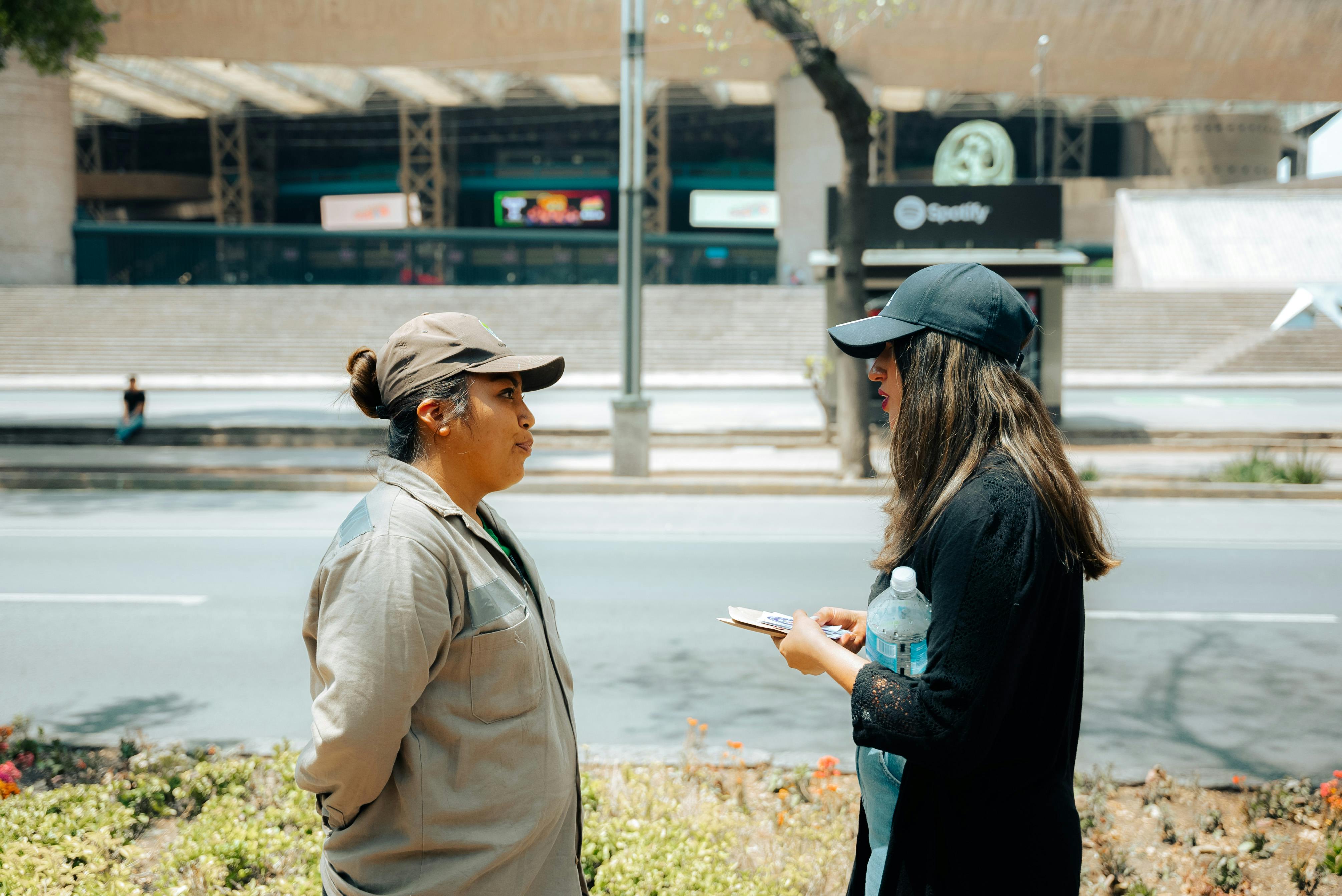 Women in Caps Talking · Free Stock Photo