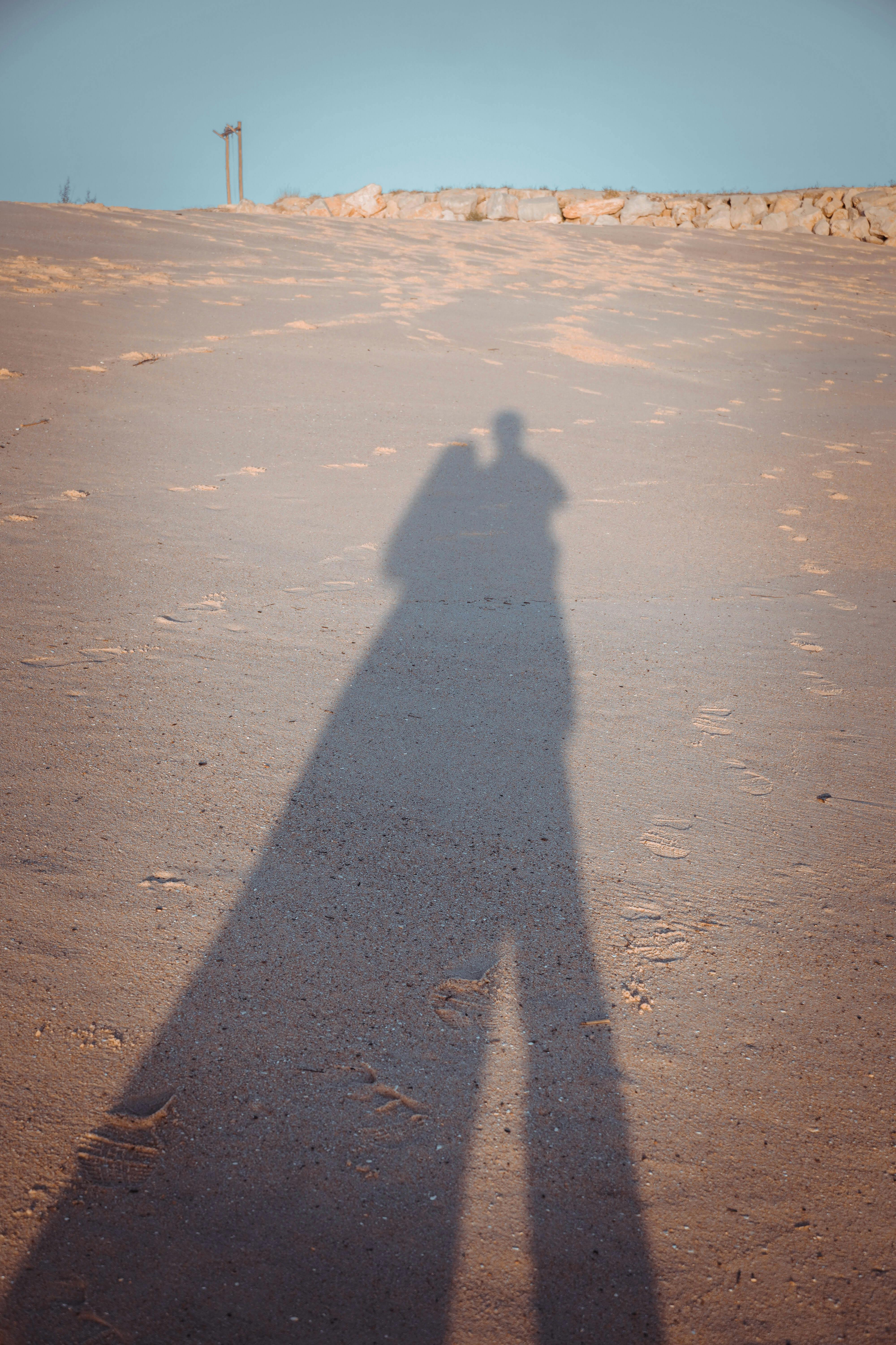 Shadow of Couple Holding Hands Cast on Boulder · Free Stock Photo