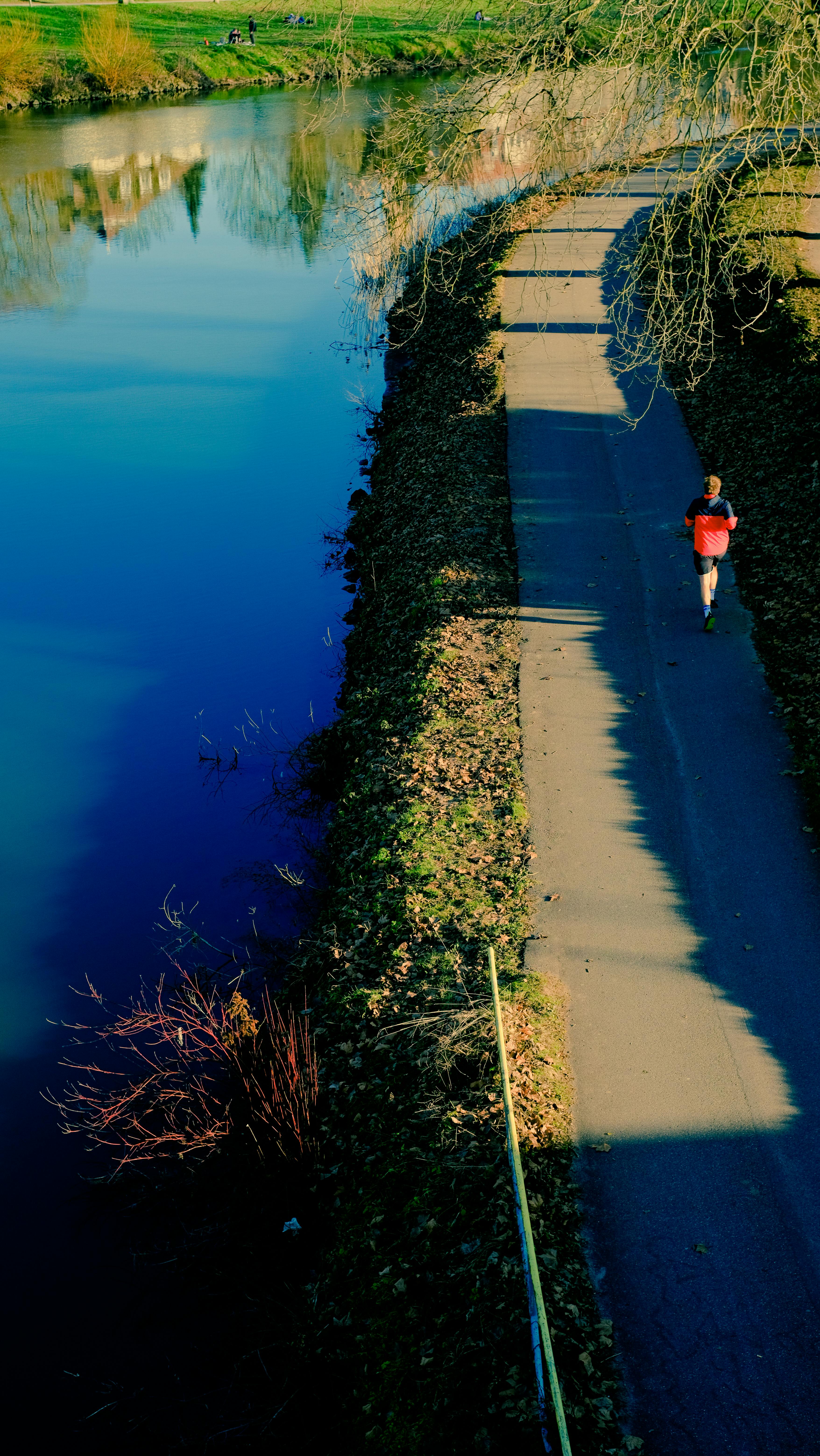 Person Running on Road near River · Free Stock Photo