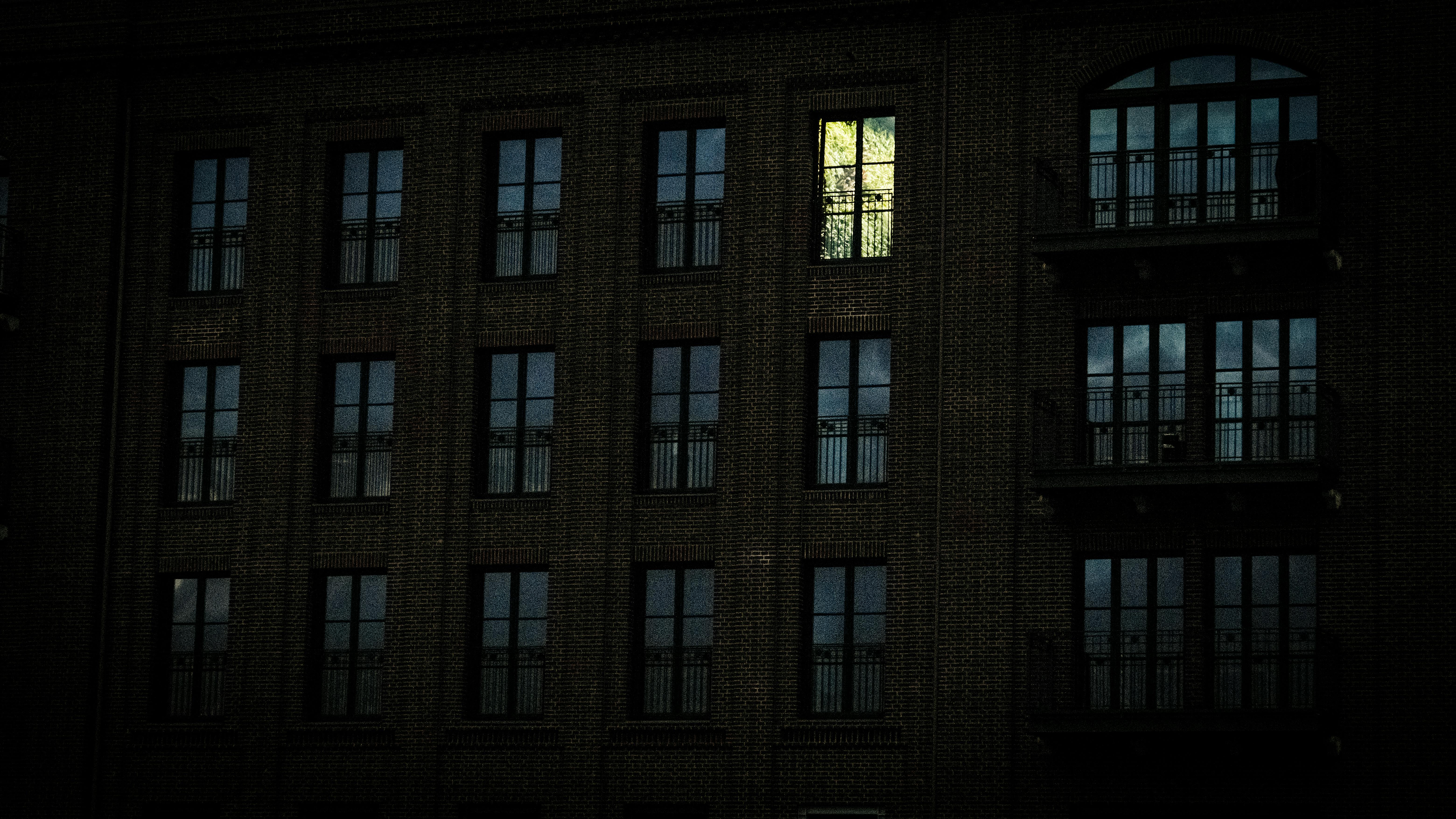 Dark Building with One Illuminated Window · Free Stock Photo