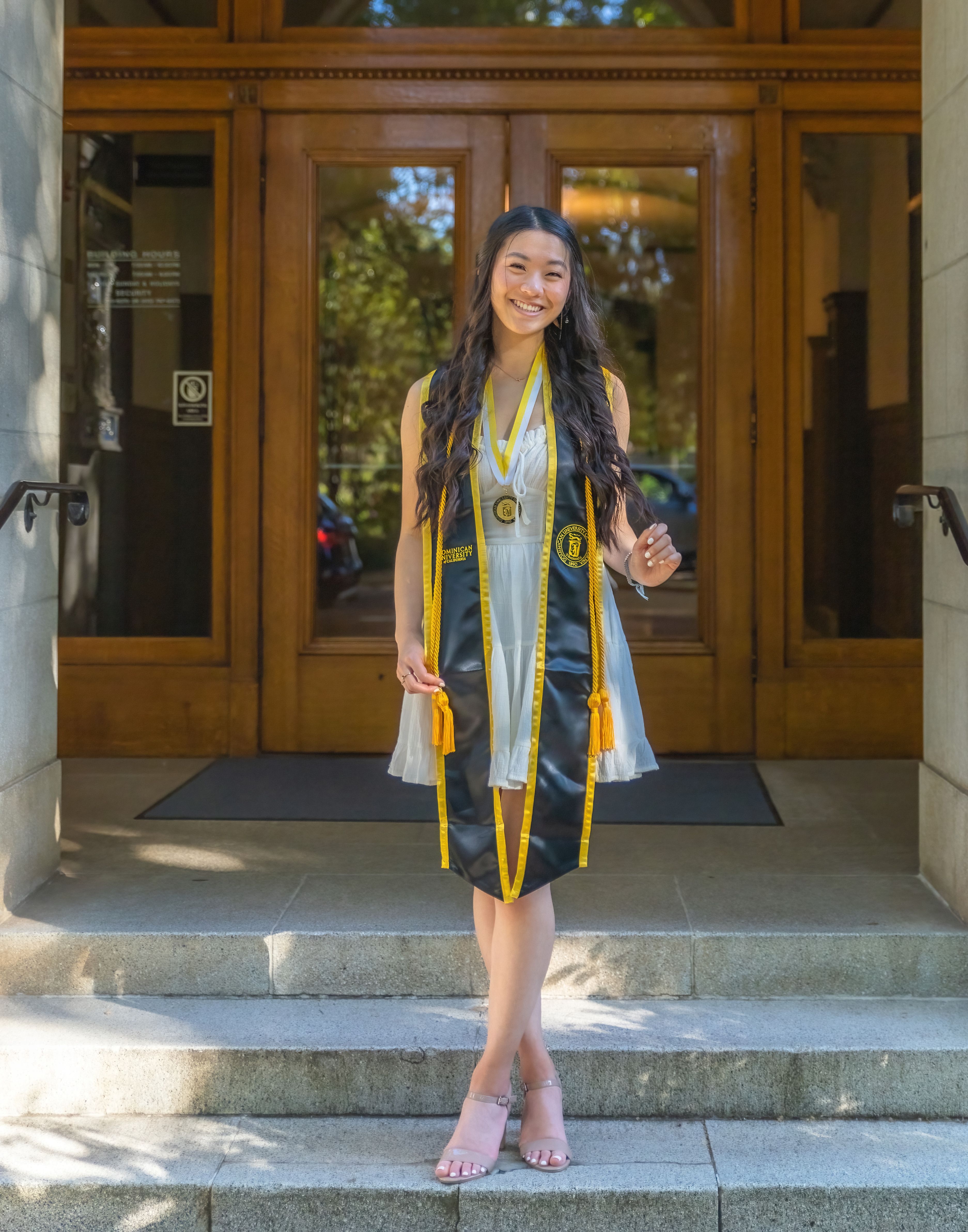 Woman Wearing White Dress and Graduation Sash Standing in front of ...