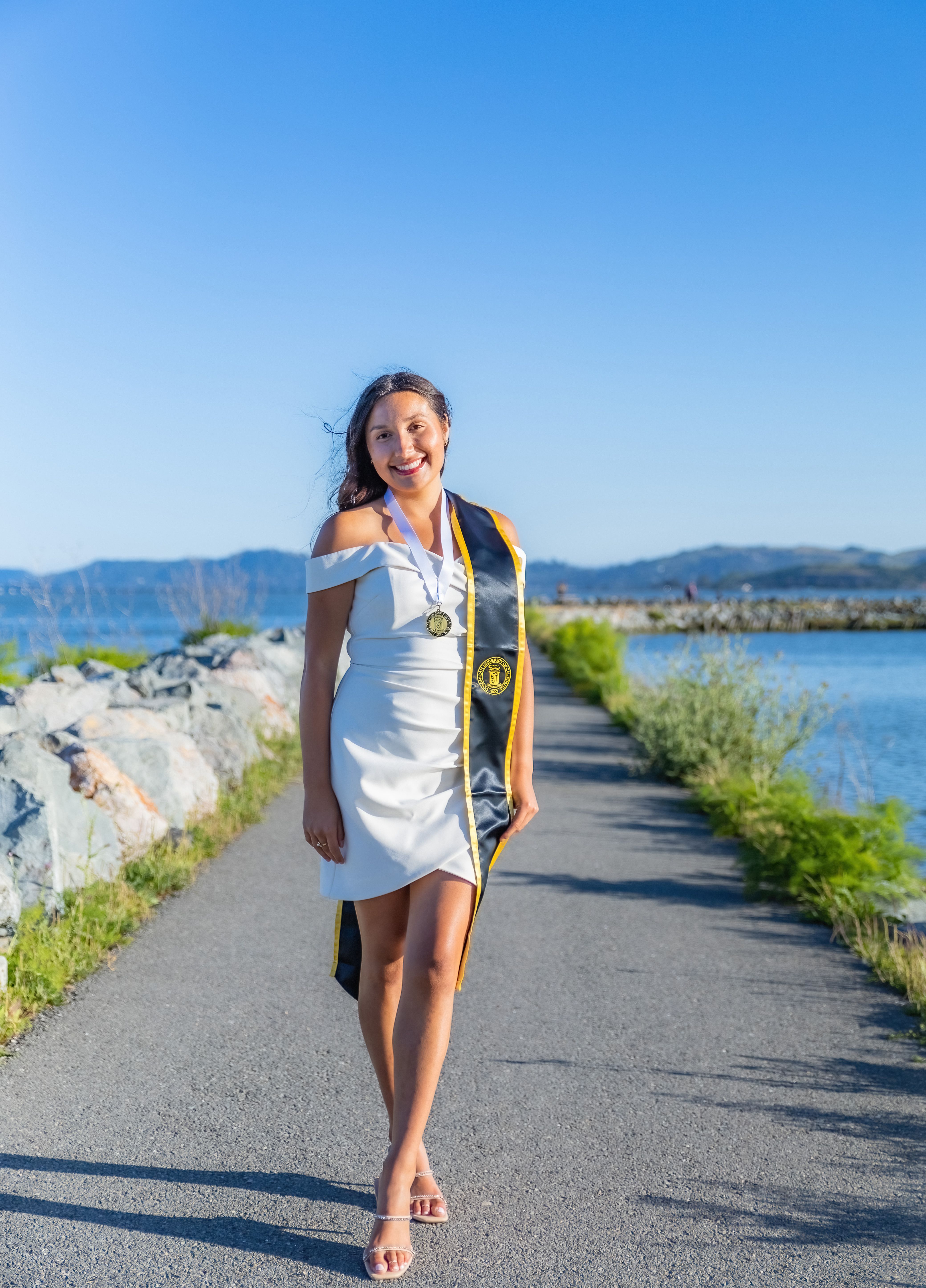 Woman Wearing White Dress and Sash Standing on Pathway Extending into ...