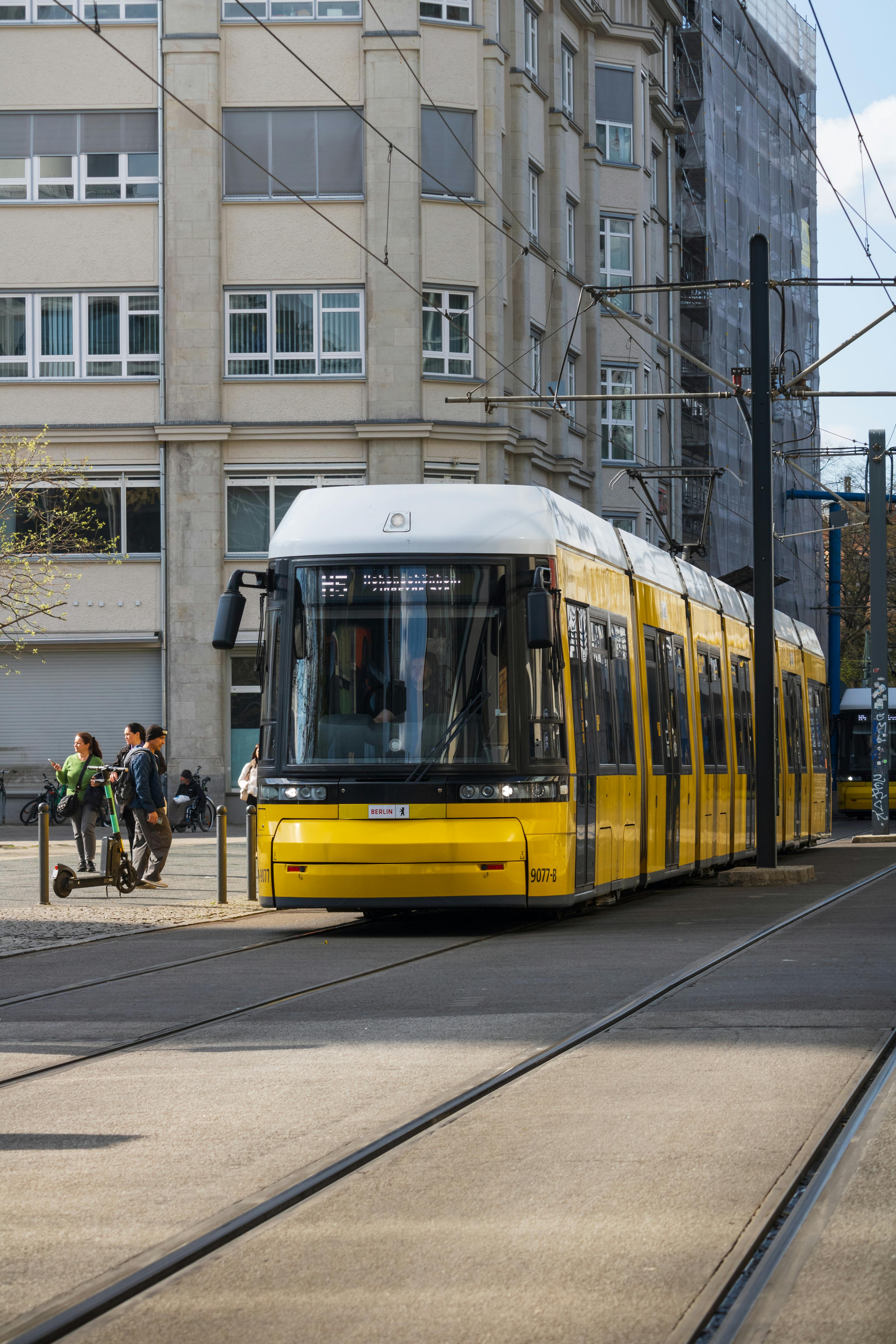A yellow and white tram on a city street · Free Stock Photo