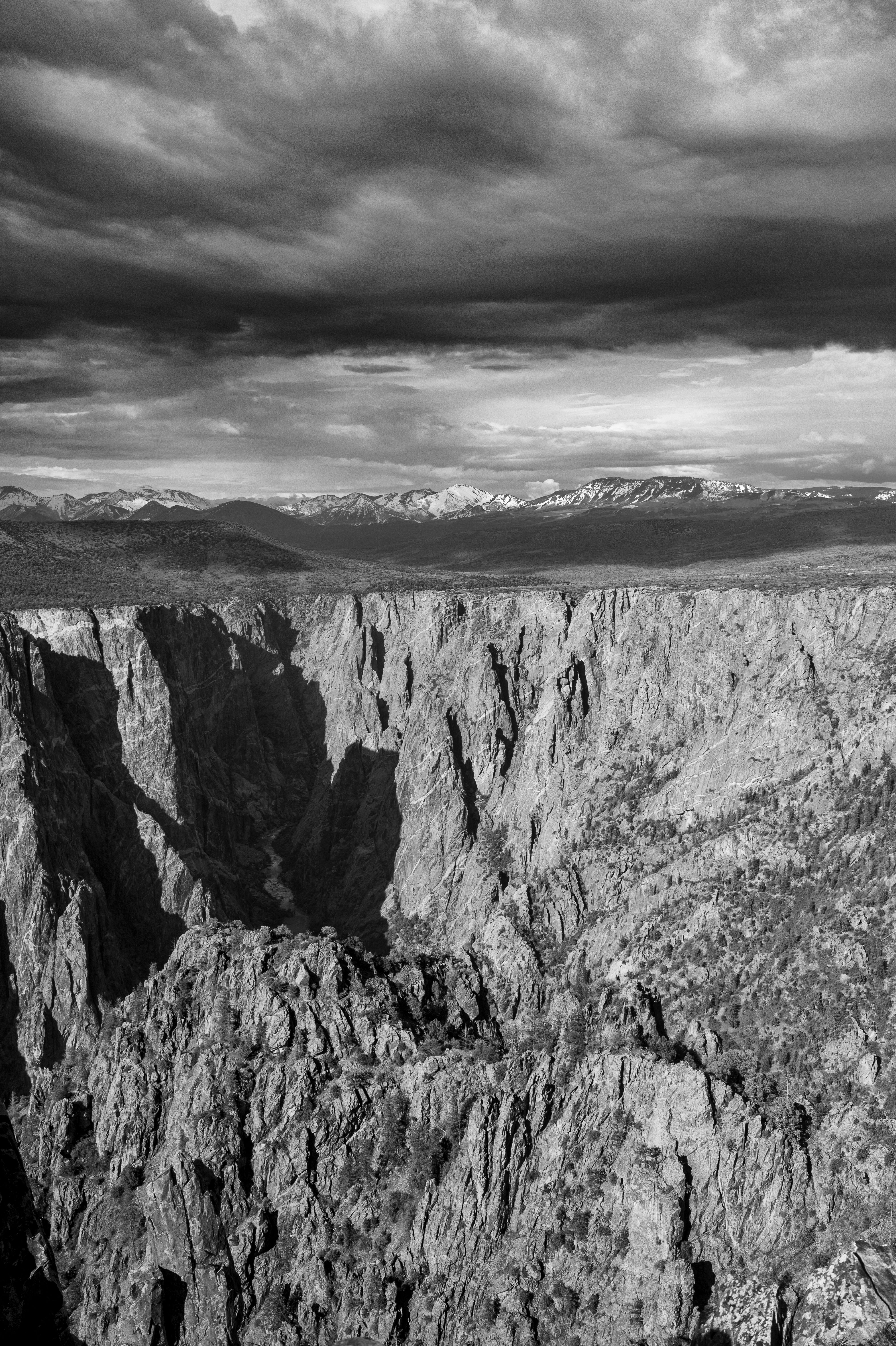 Storm Clouds over a Tall Cliff with Mountains in the Background · Free ...