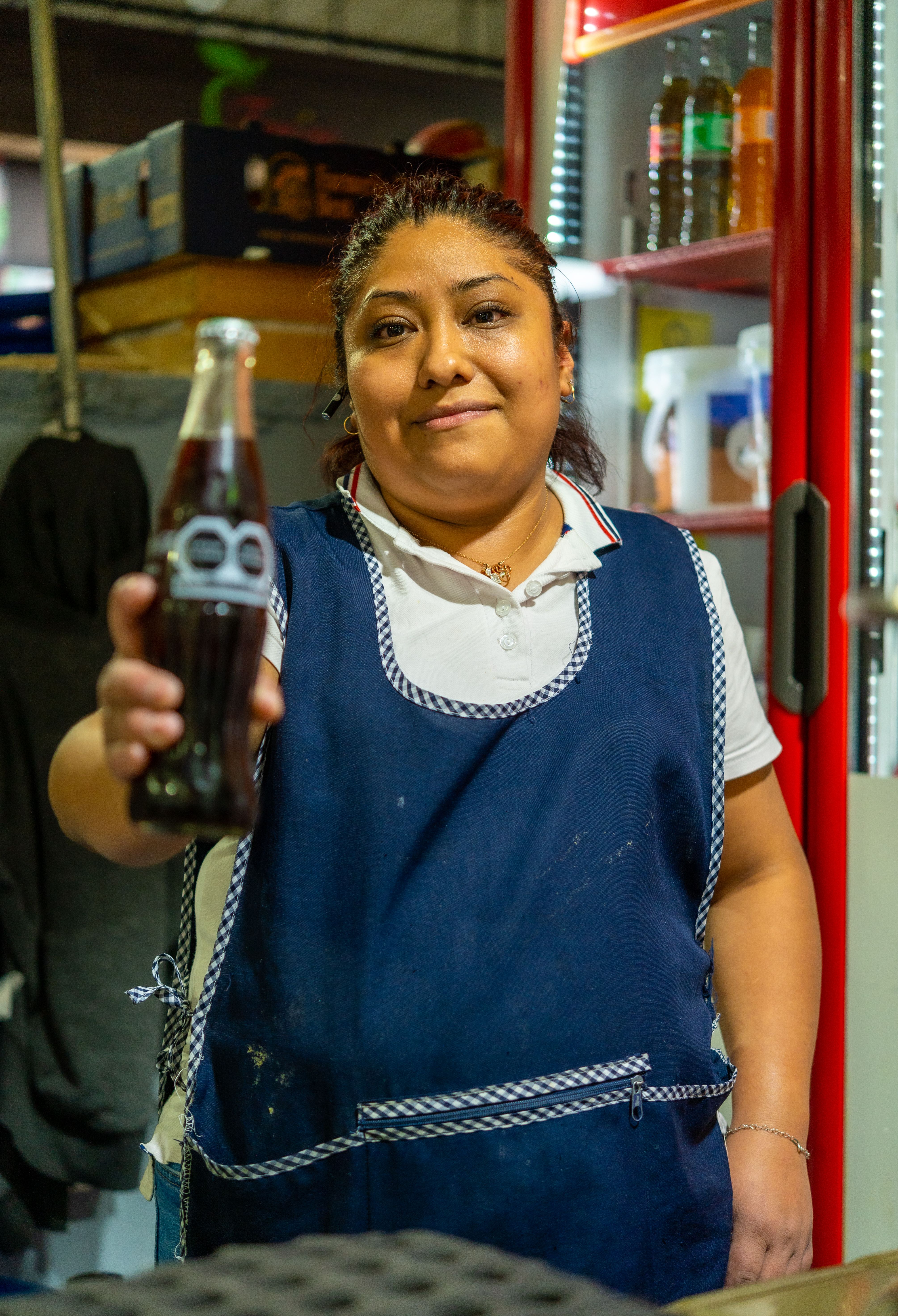 Woman in Apron Holding Coca Cola Bottle · Free Stock Photo