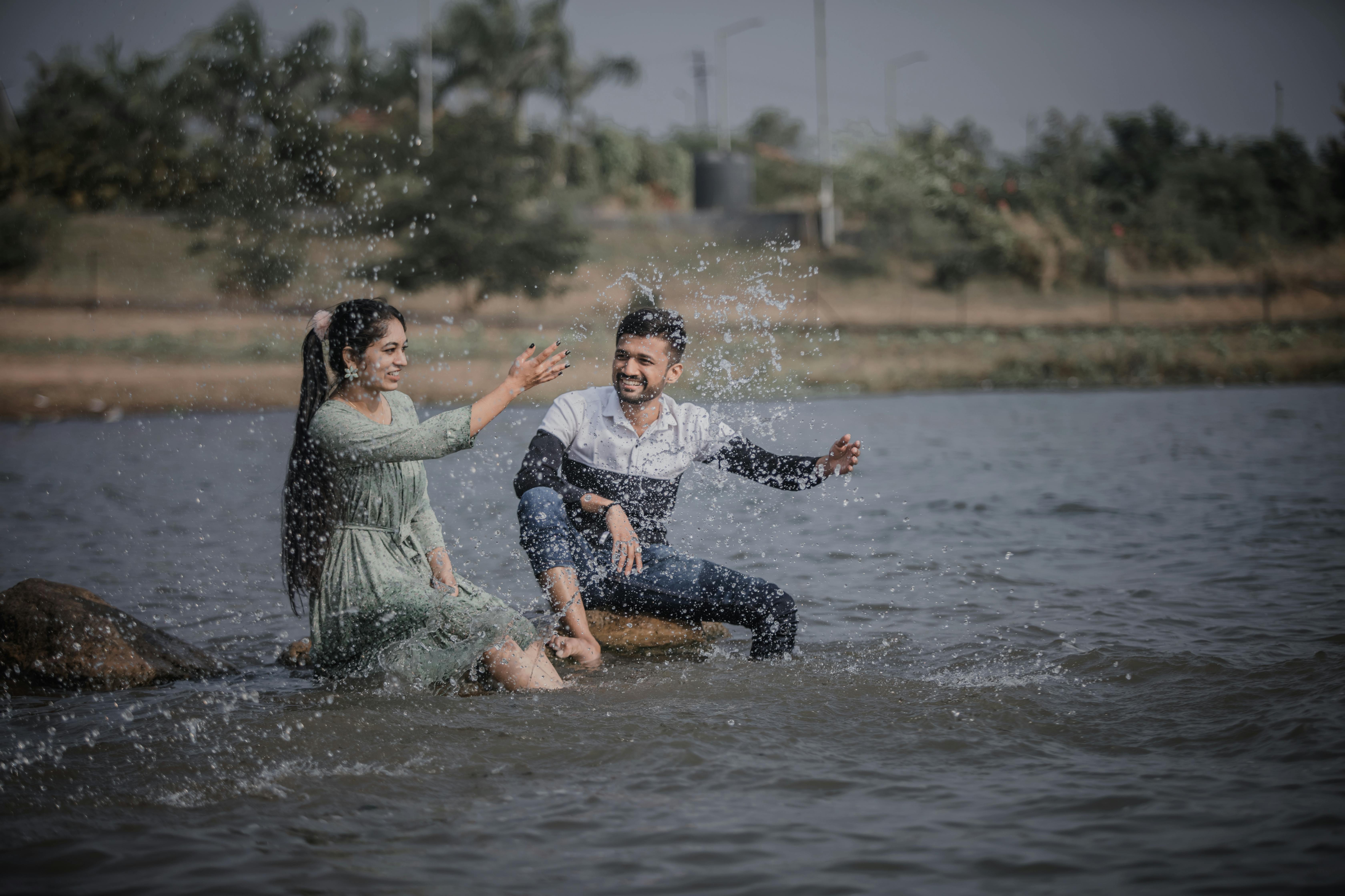 Sitting Couple Splashing Water · Free Stock Photo