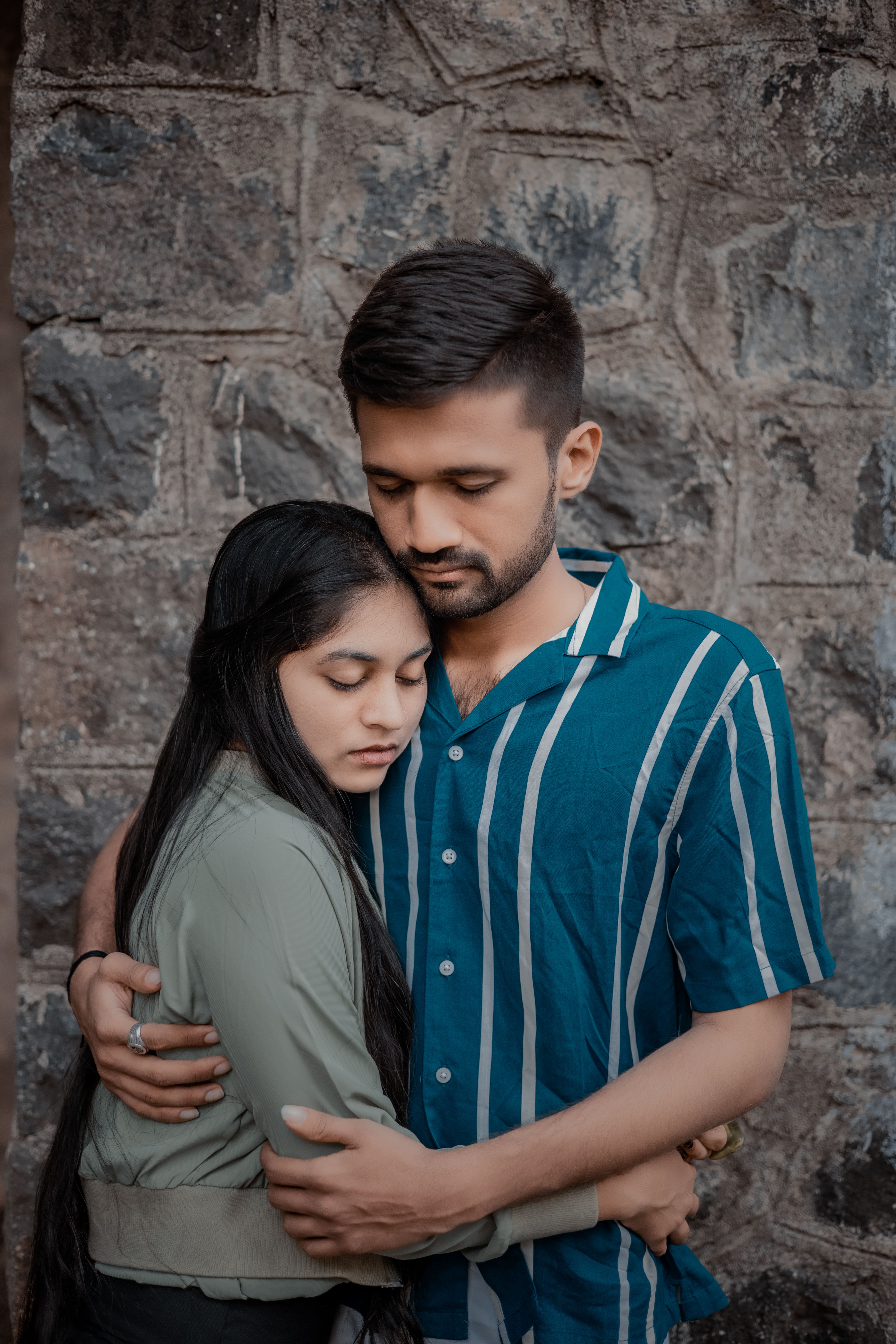 Embracing Couple by Wall · Free Stock Photo
