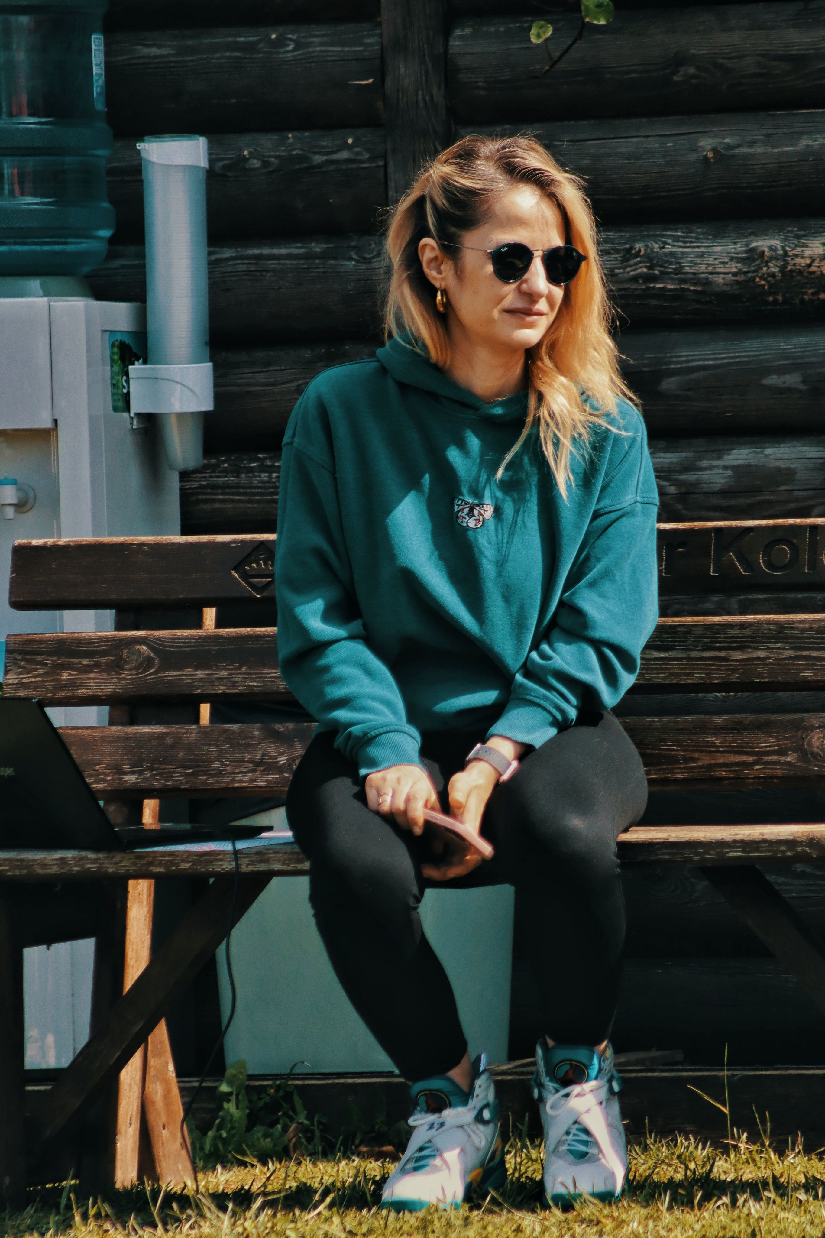 Young Woman in a Casual Outfit Sitting on a Wooden Bench · Free Stock Photo