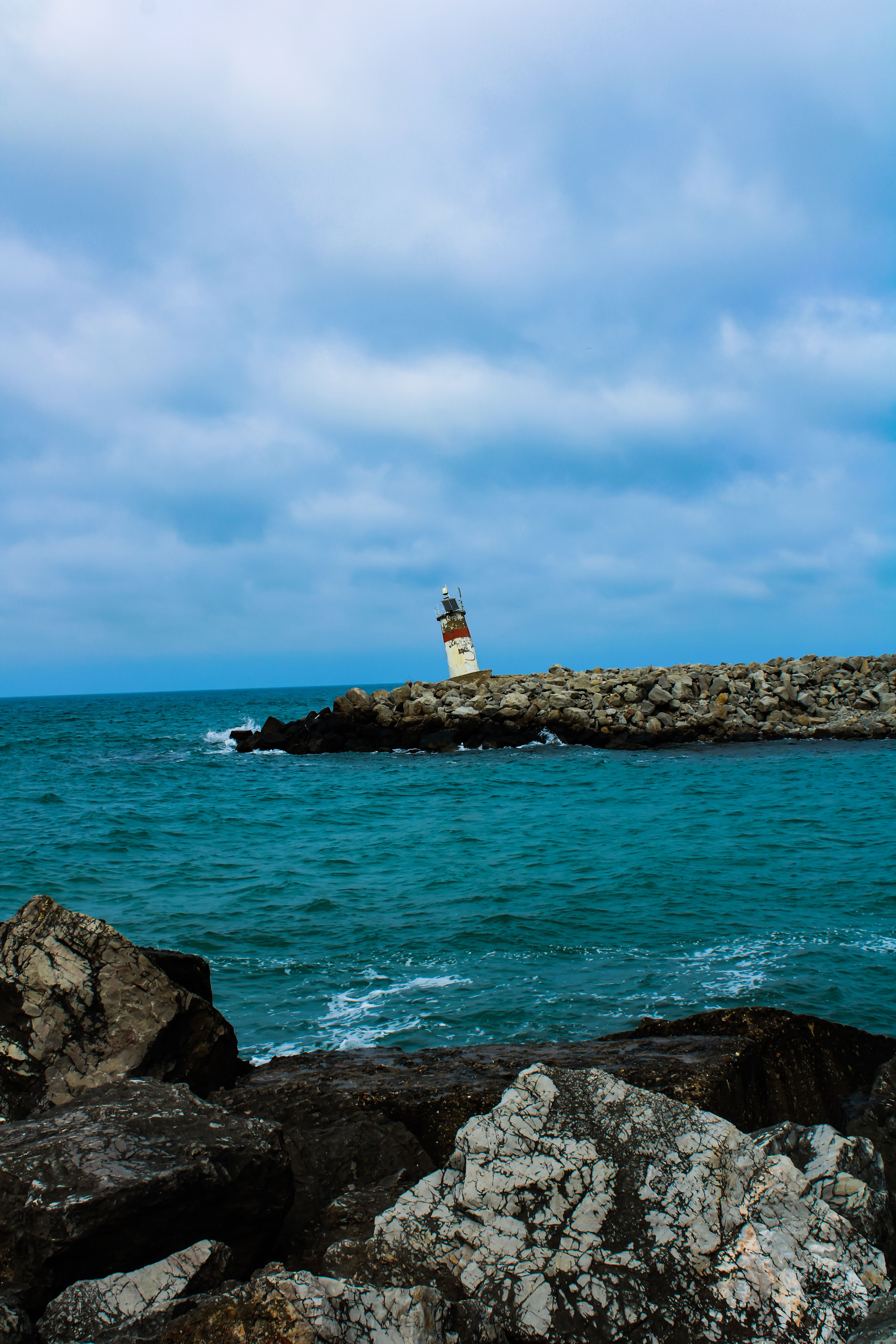 Rocks on Sea Coast with Lighthouse Ruins behind · Free Stock Photo