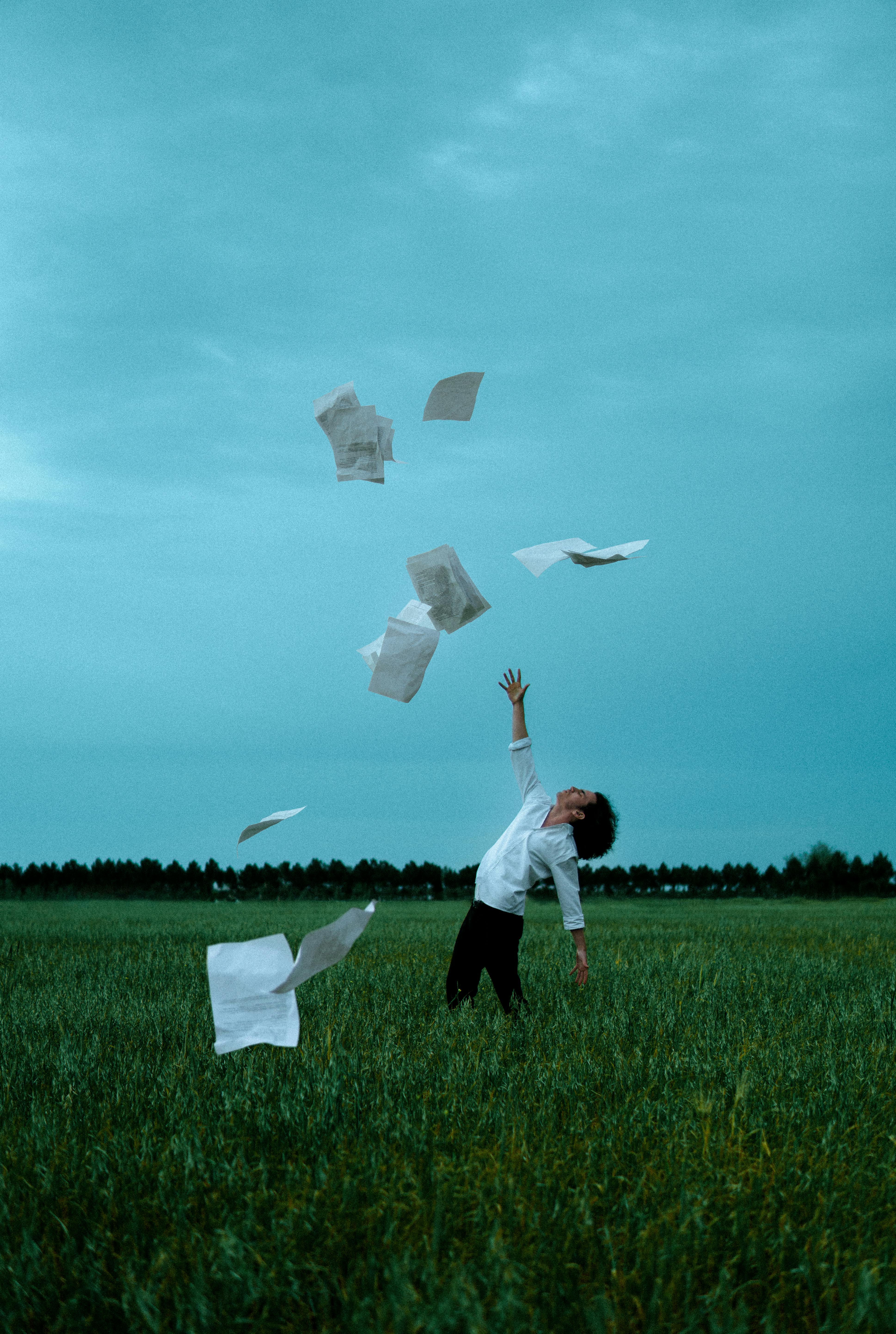 A Man in the Field Scattering Papers · Free Stock Photo