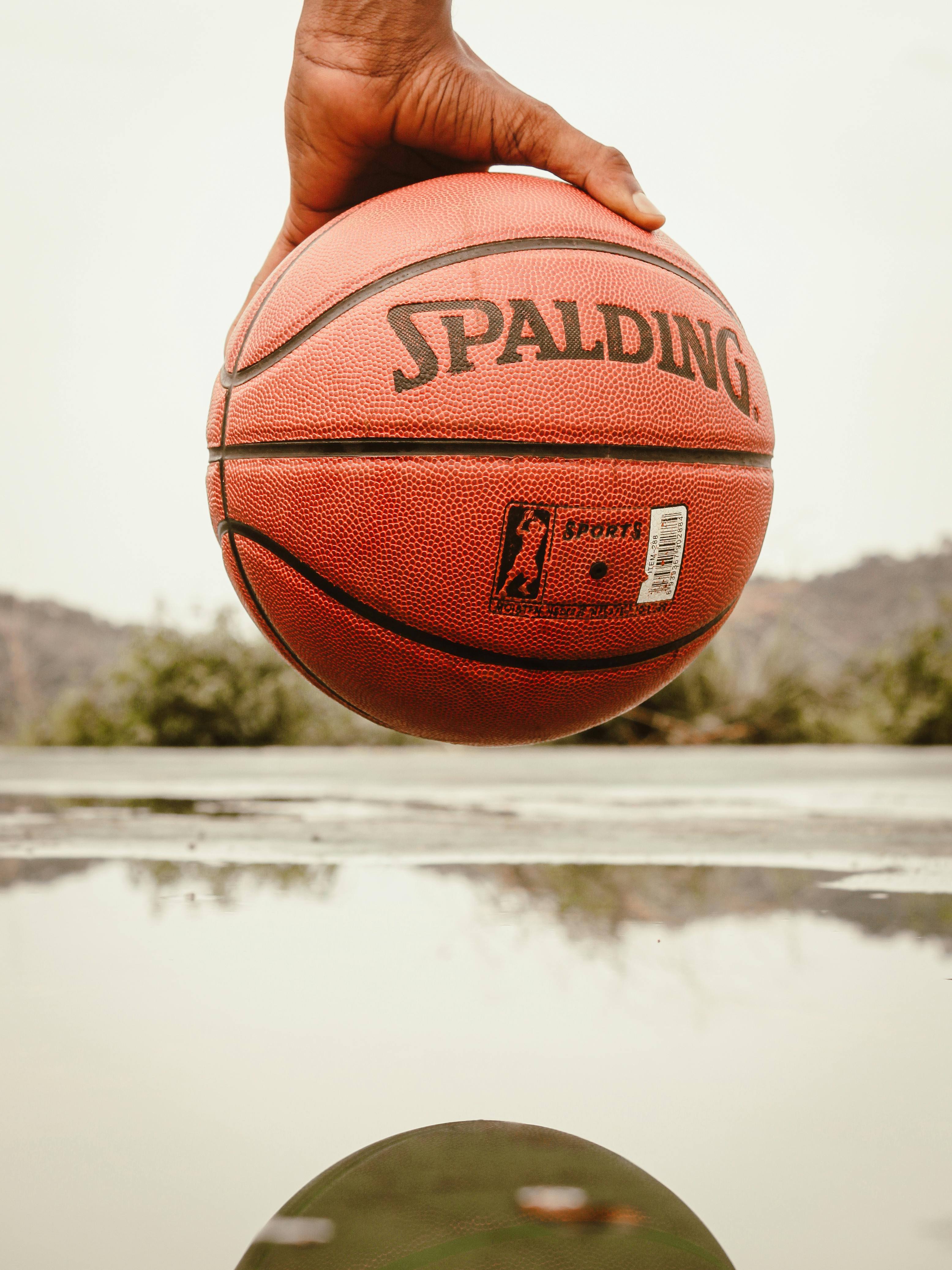 Hand Holding Ball over Puddle · Free Stock Photo