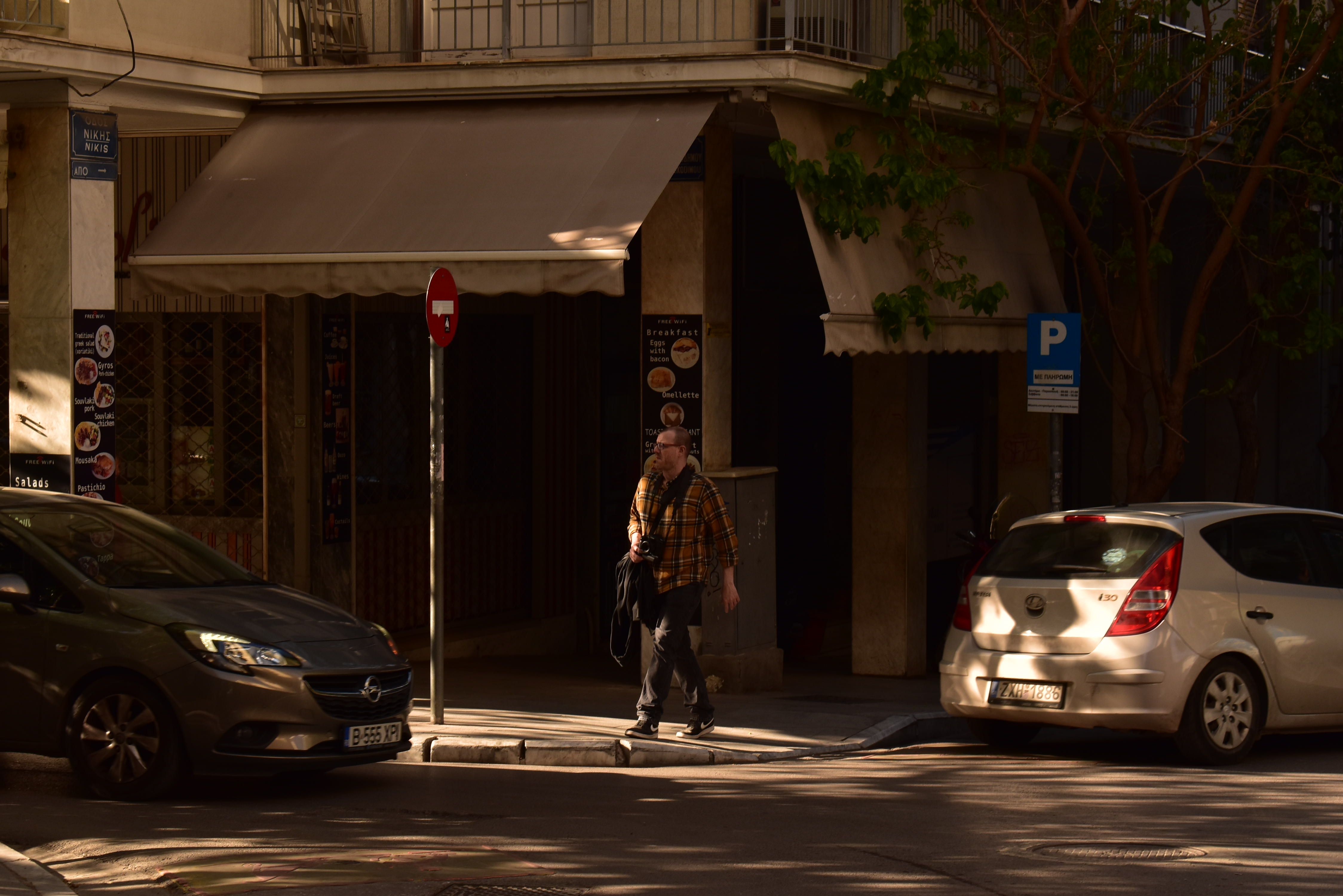 Man Walking near Cars on Street · Free Stock Photo