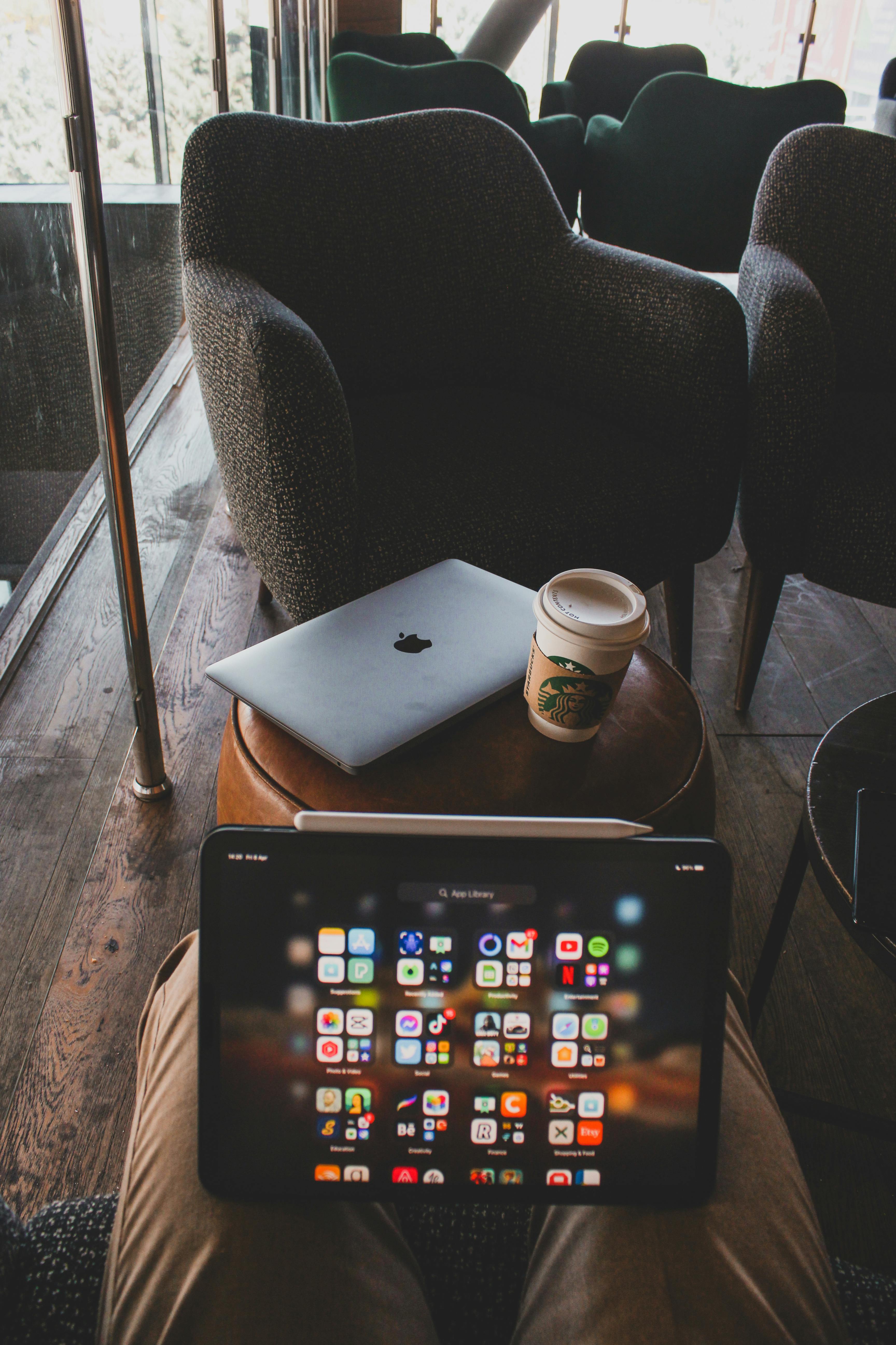 Tablet Screen and MacBook on Table behind · Free Stock Photo