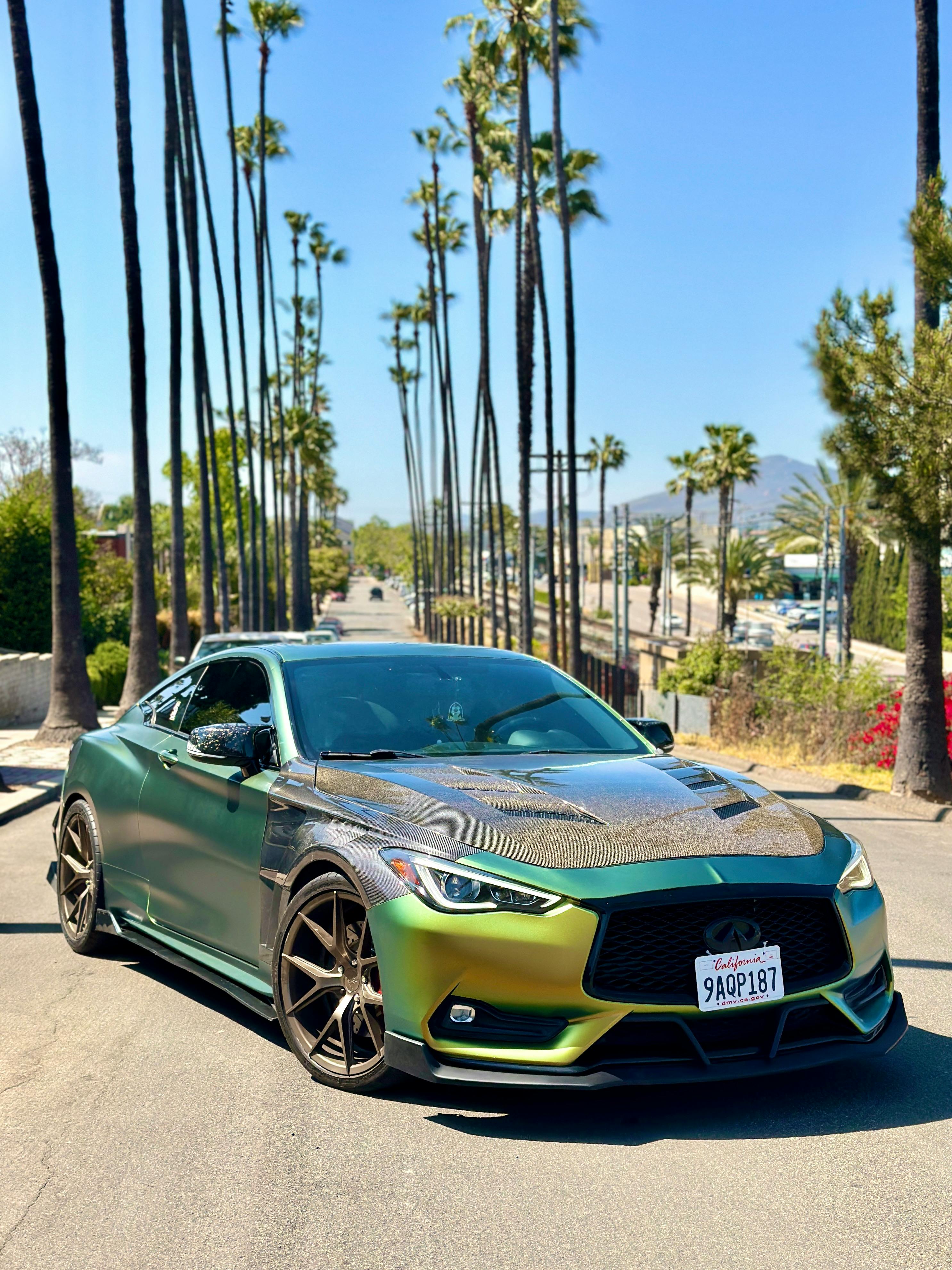 An Infiniti Q60 in a Green Car Wrap Parked on a Street with Palm Trees ...