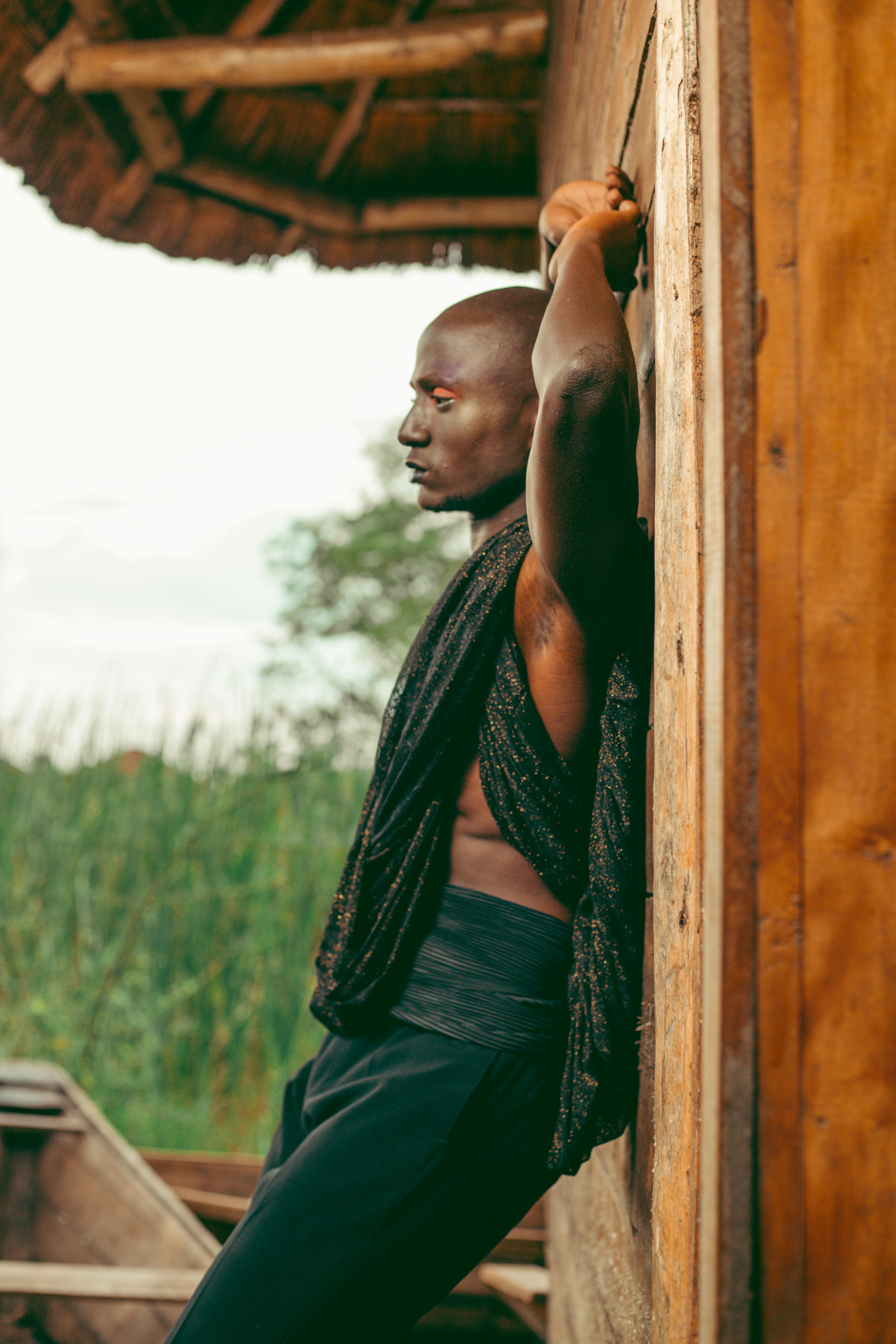 Man Posing by Wooden Cottage Wall · Free Stock Photo