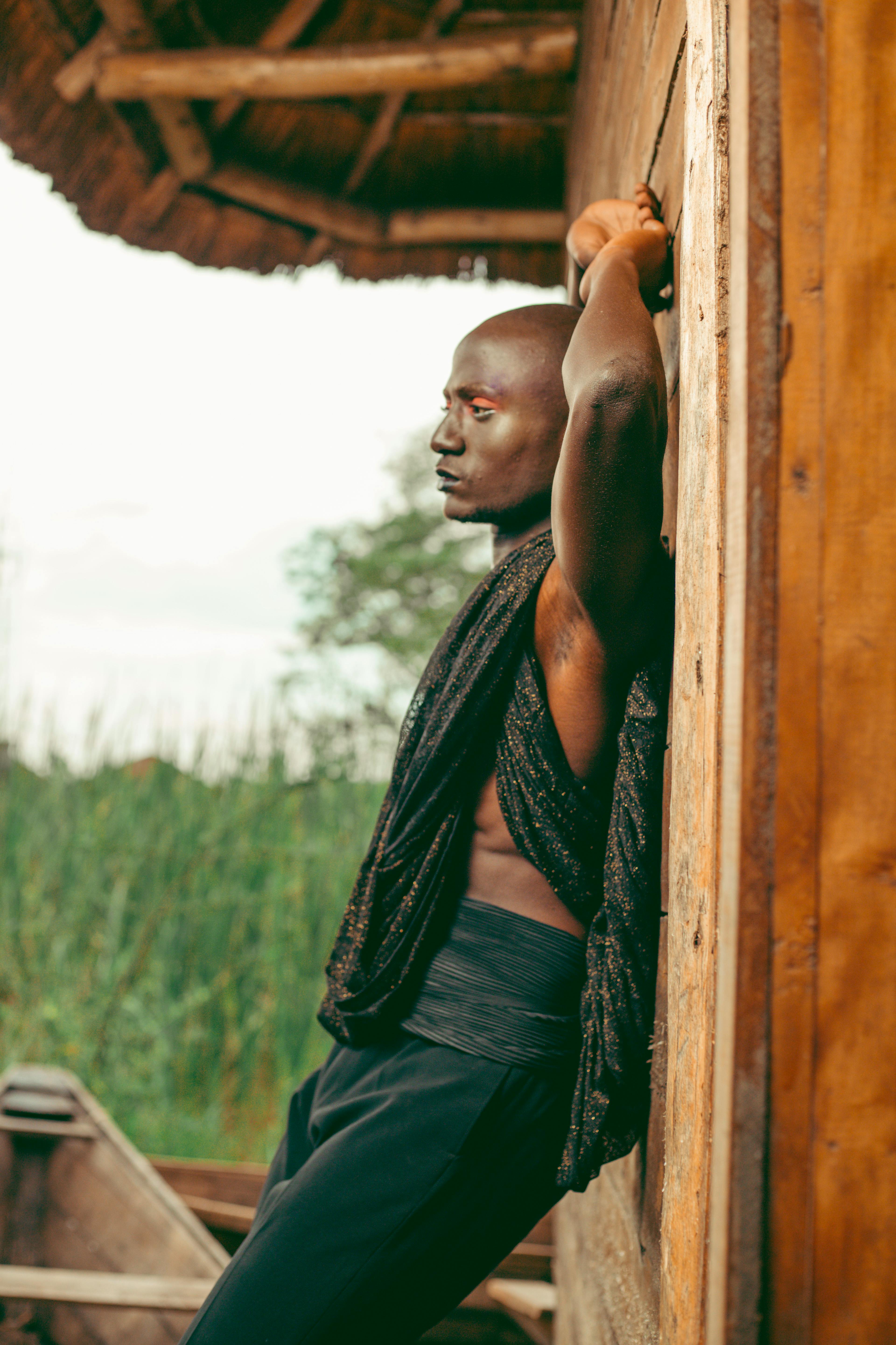 Man Leaning on Hut Wall · Free Stock Photo