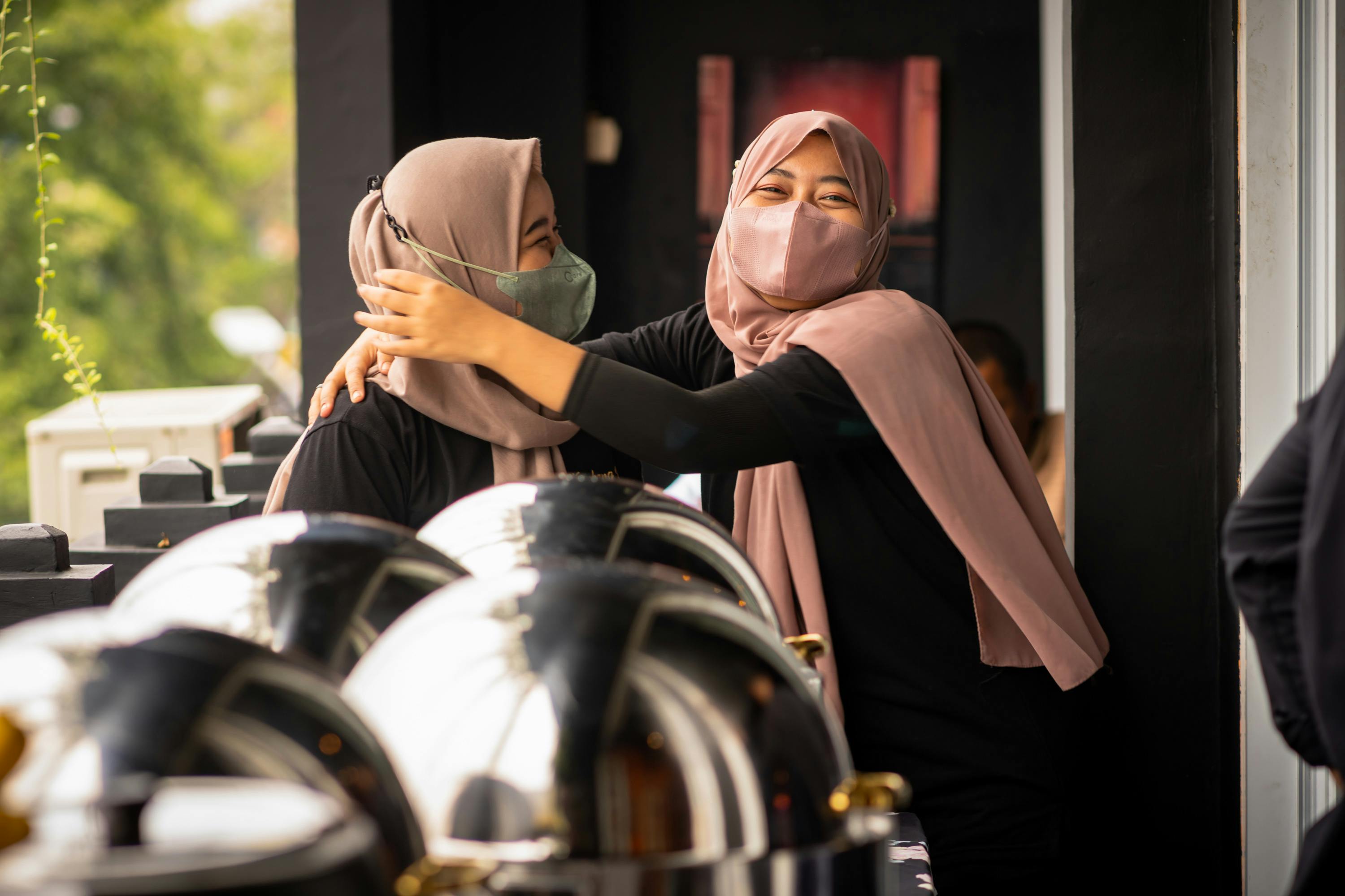 Women in Hijab and Face Masks Hugging Each Other · Free Stock Photo