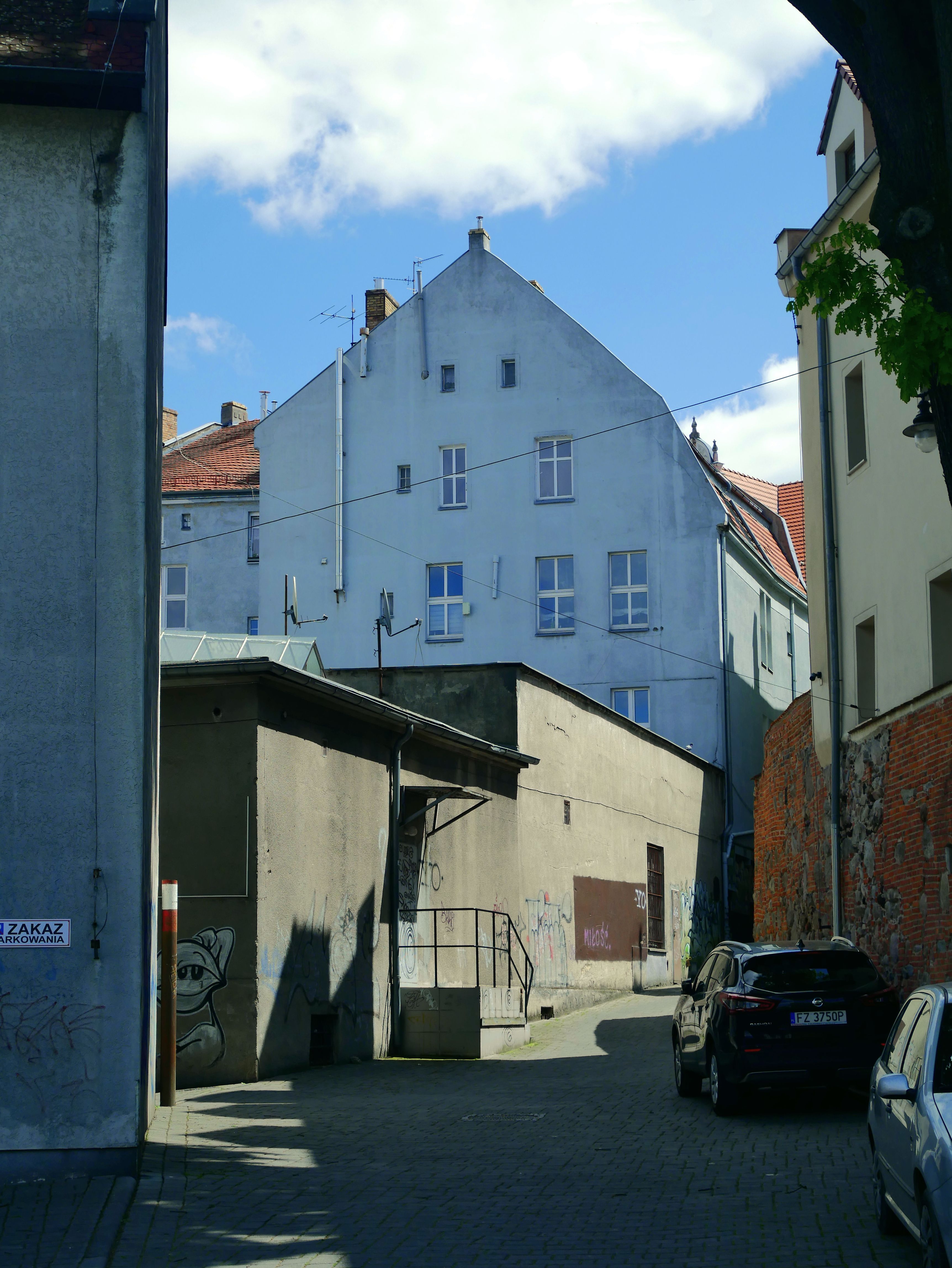 An Alley between Residential Buildings in City with Cars Parked on the ...
