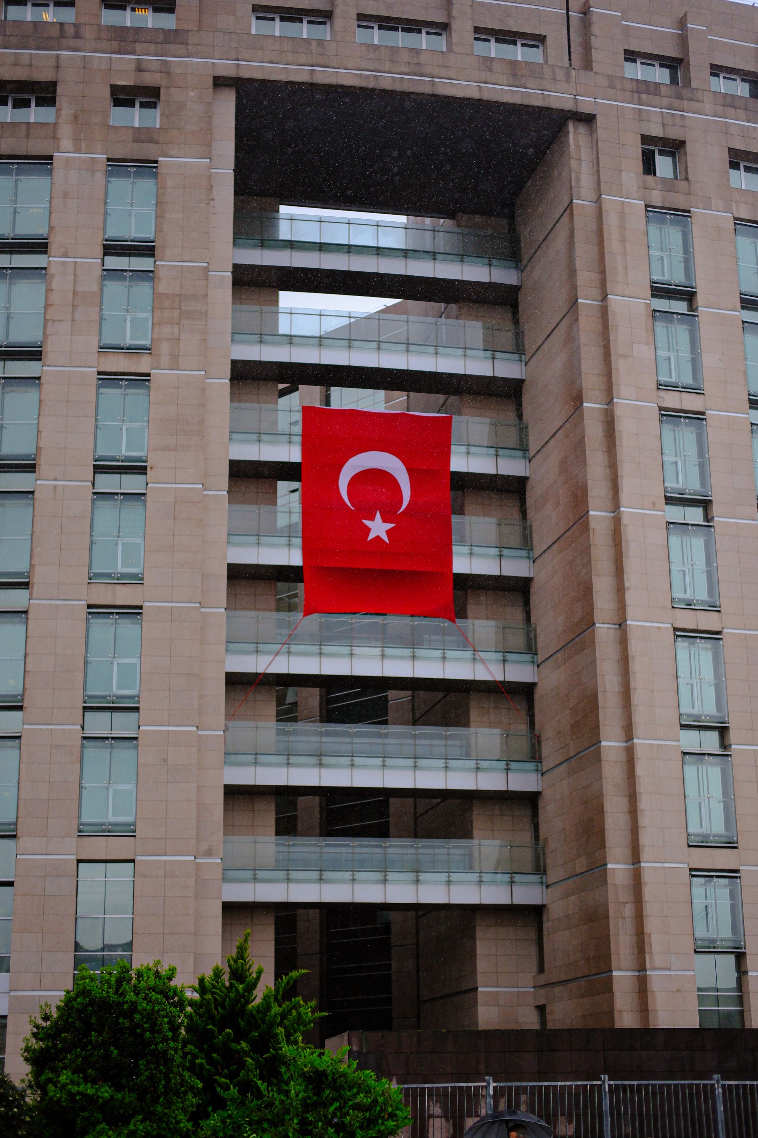 A large building with a large flag hanging from the top · Free Stock Photo