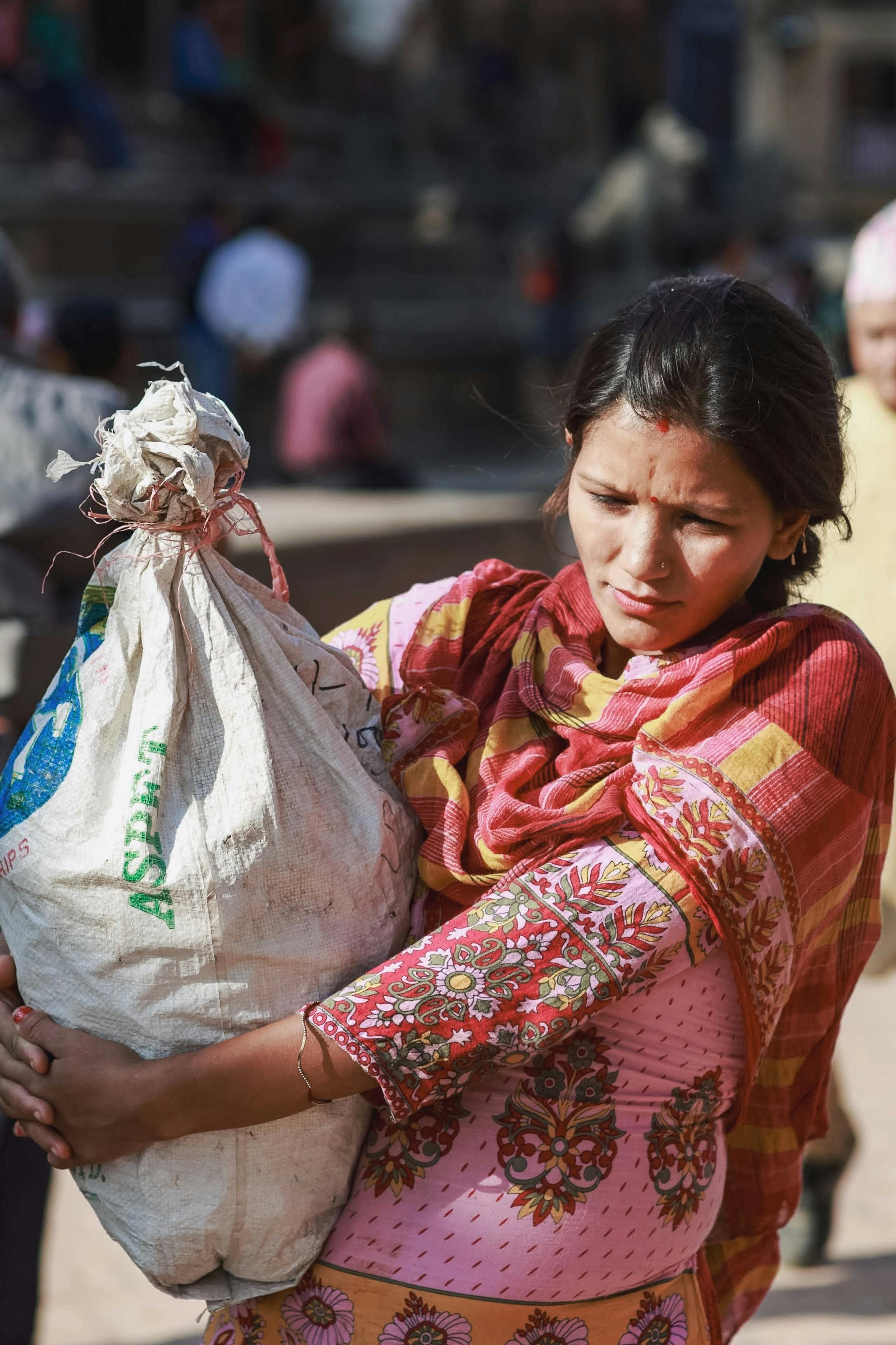 Candid Picture of a Woman Carrying a Sack · Free Stock Photo