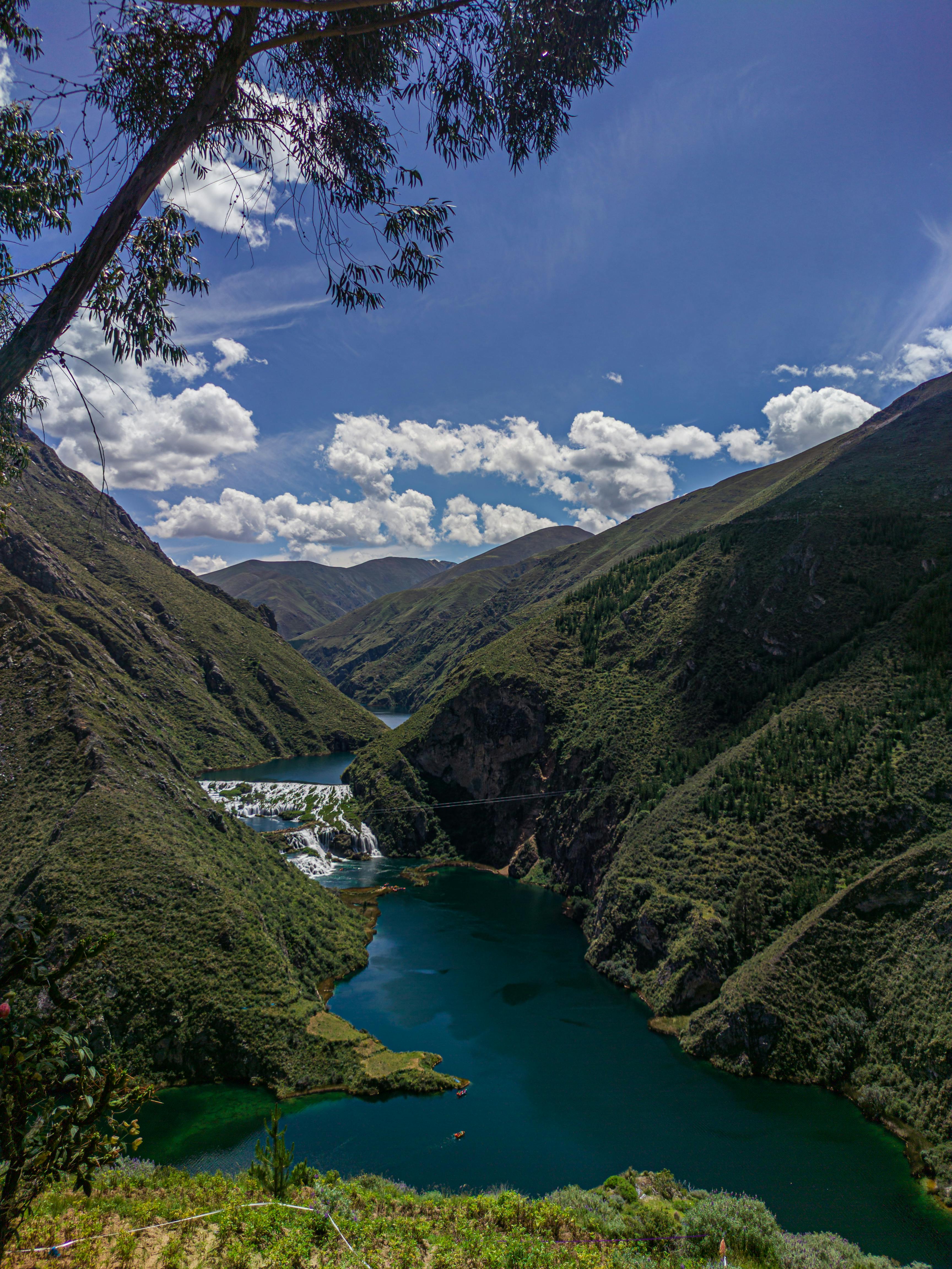 Girl in Peruvian Traditional Clothing Sitting by Lake · Free Stock Photo