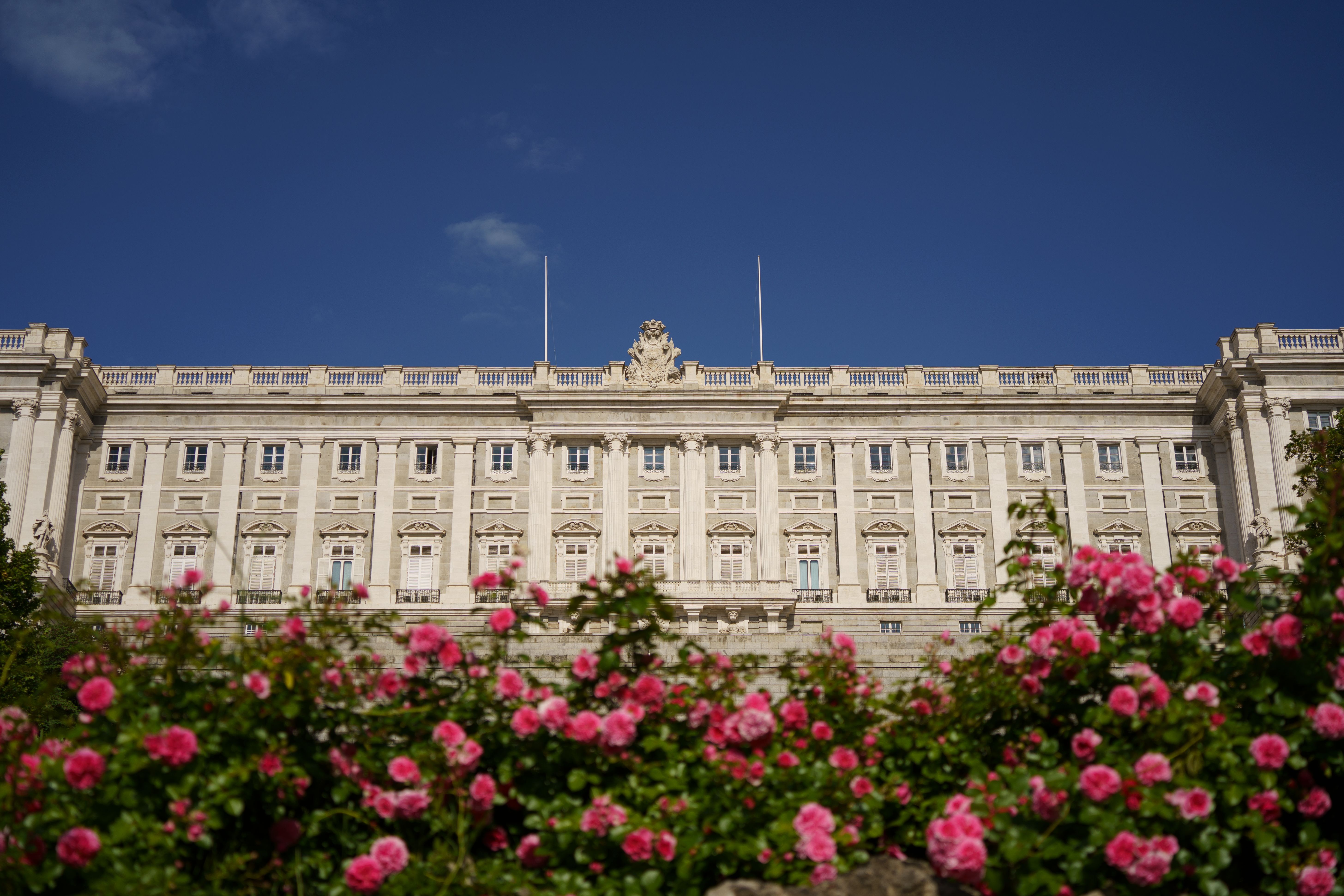 View of Pink Roses and Facade of the Royal Palace of Madrid, Spain ...