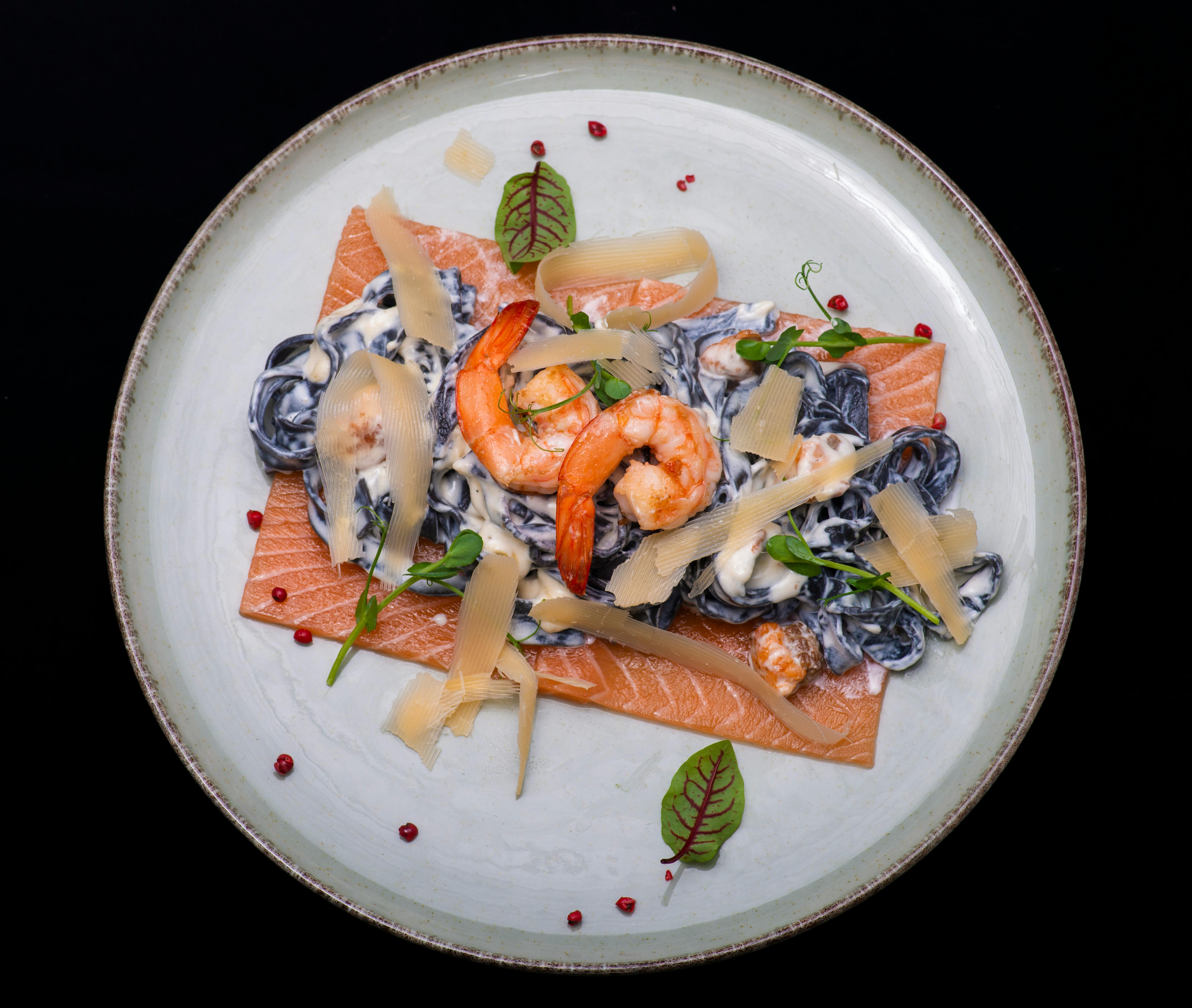 Person Eating with a Bowl of Seashells on Table and a Lighted Candle ...