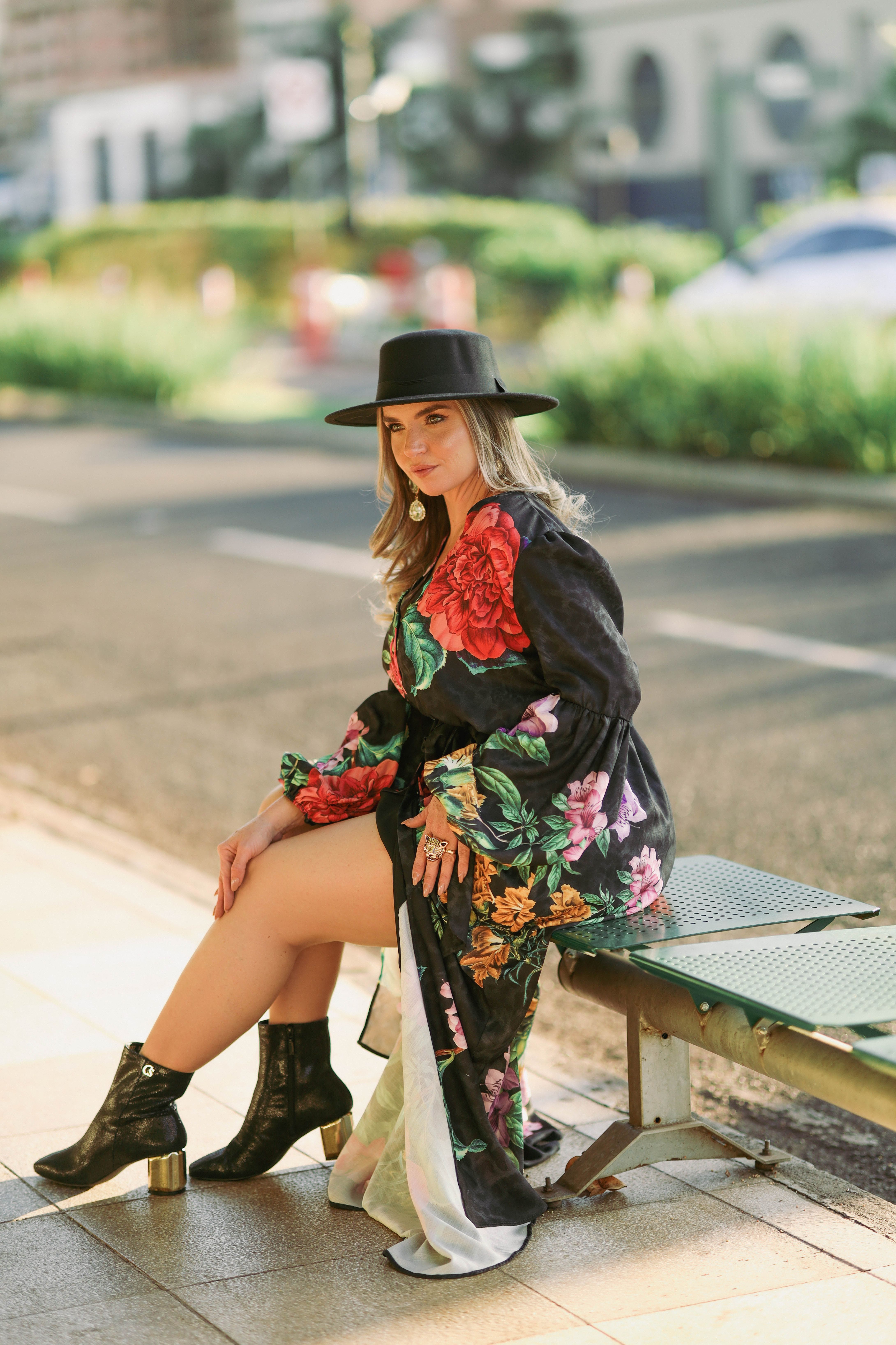 Woman Sitting on Bench near Street and Posing · Free Stock Photo