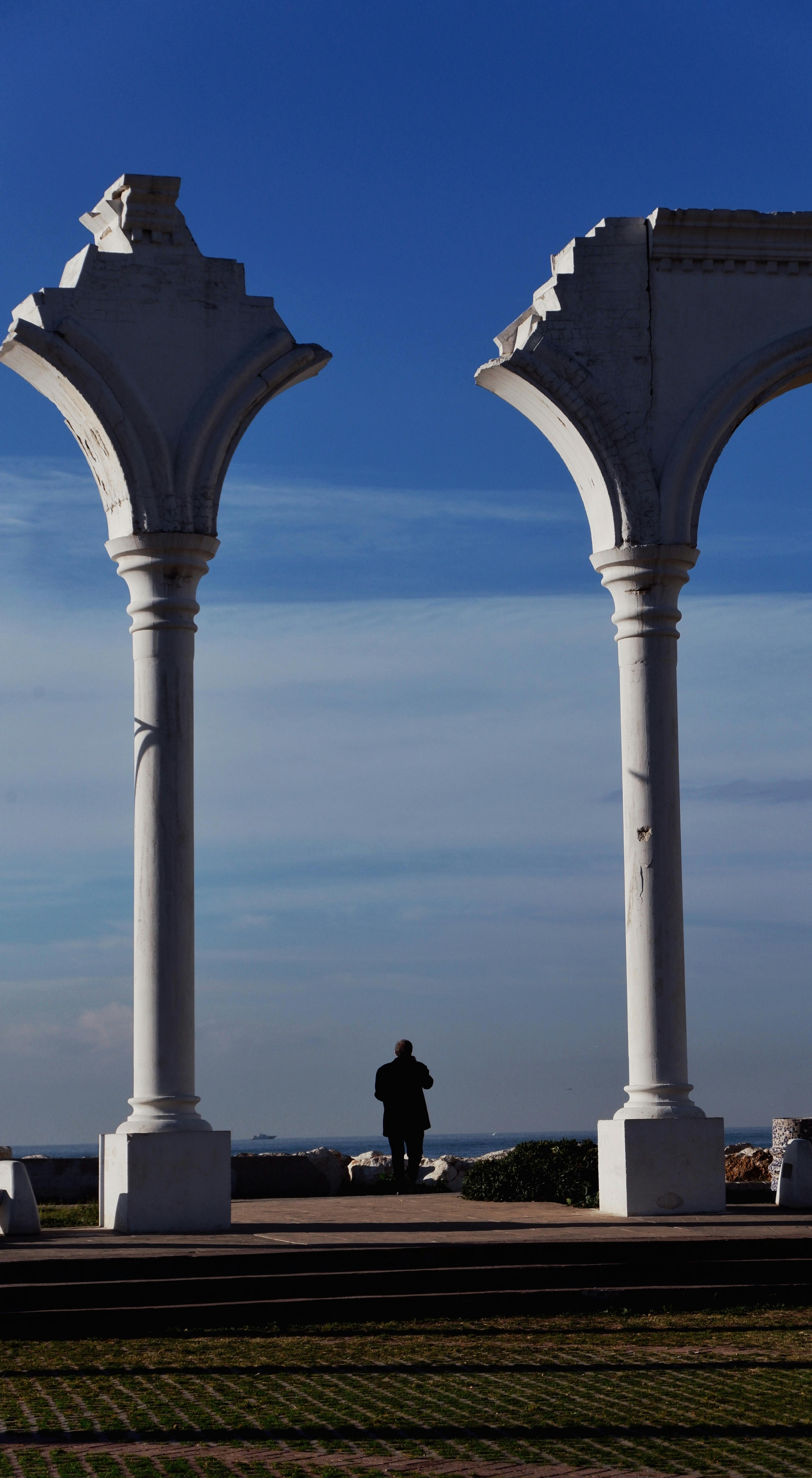 Person Standing behind Columns in Ruins · Free Stock Photo