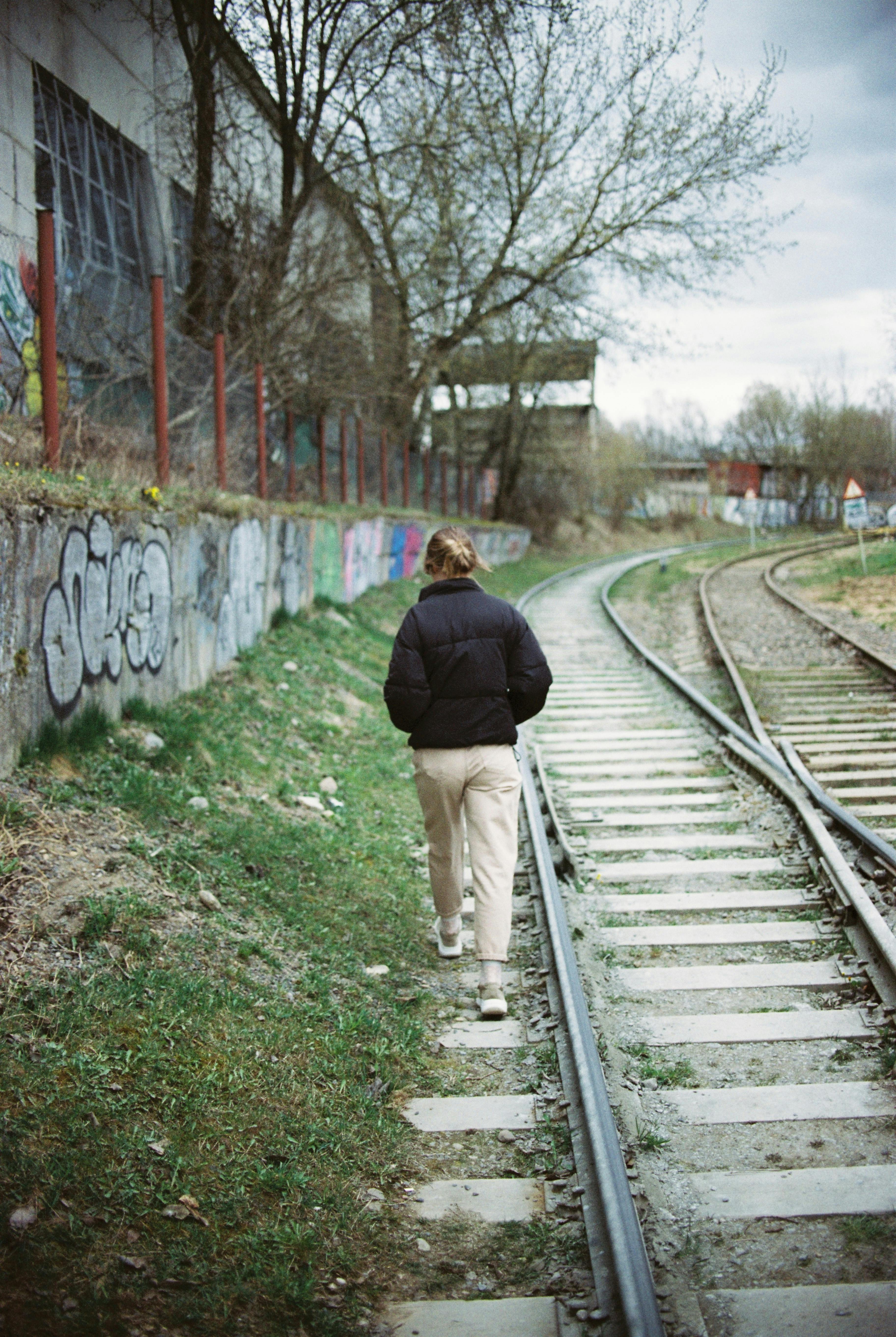 Woman Walking along Railroad Track · Free Stock Photo