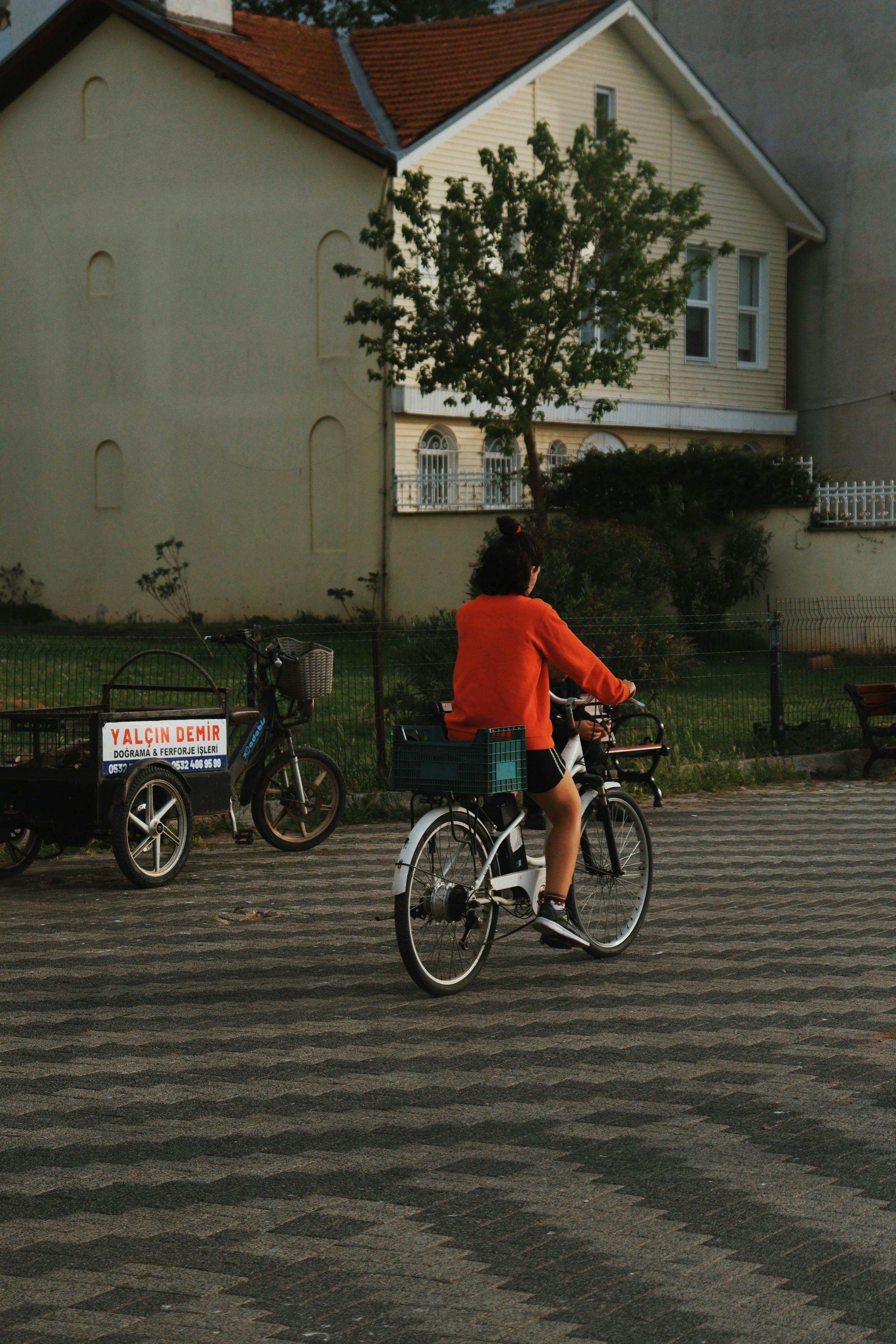 Back View of a Woman Riding a Bike · Free Stock Photo