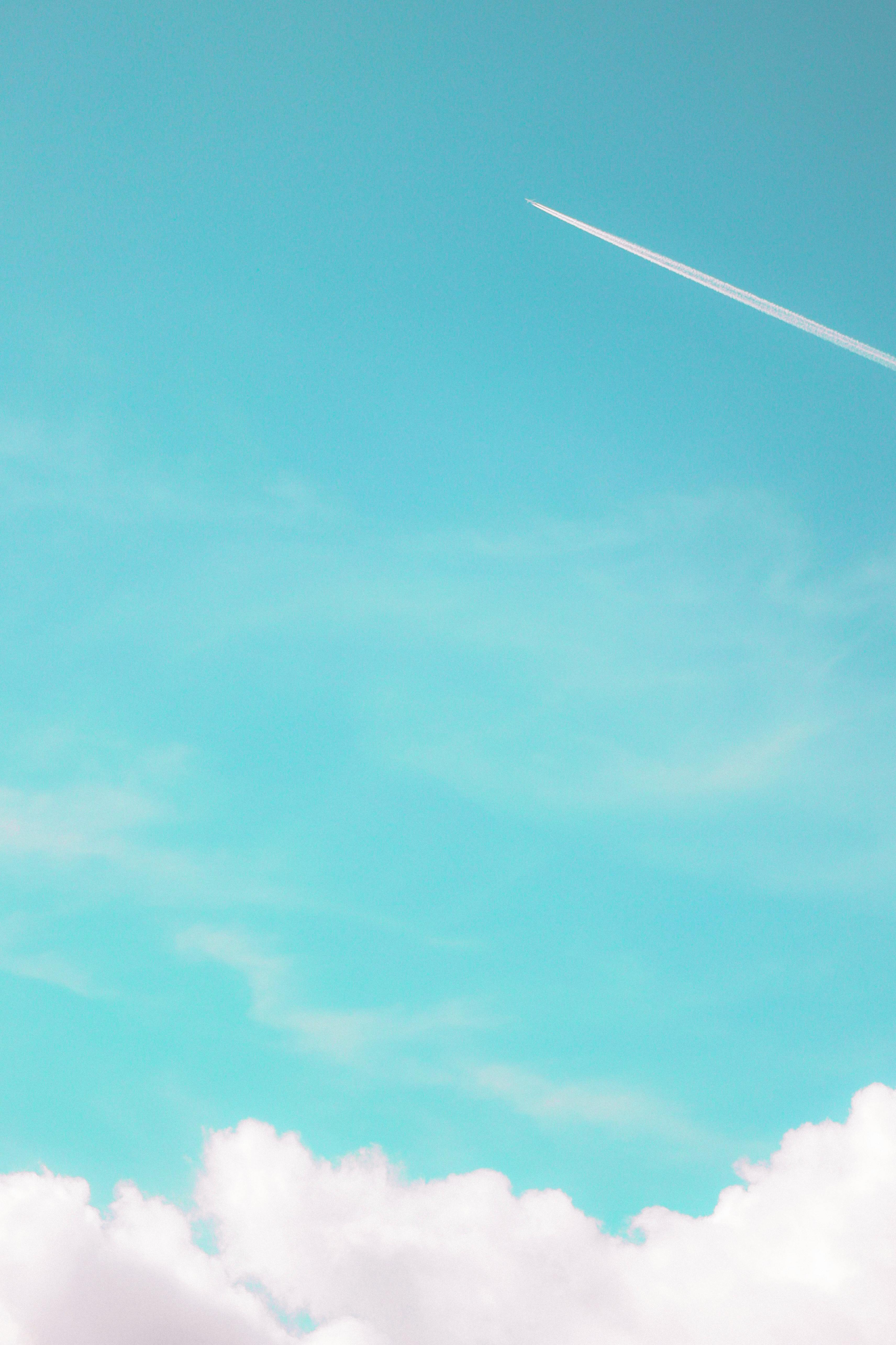 An Airplane High up against a Blue Sky · Free Stock Photo
