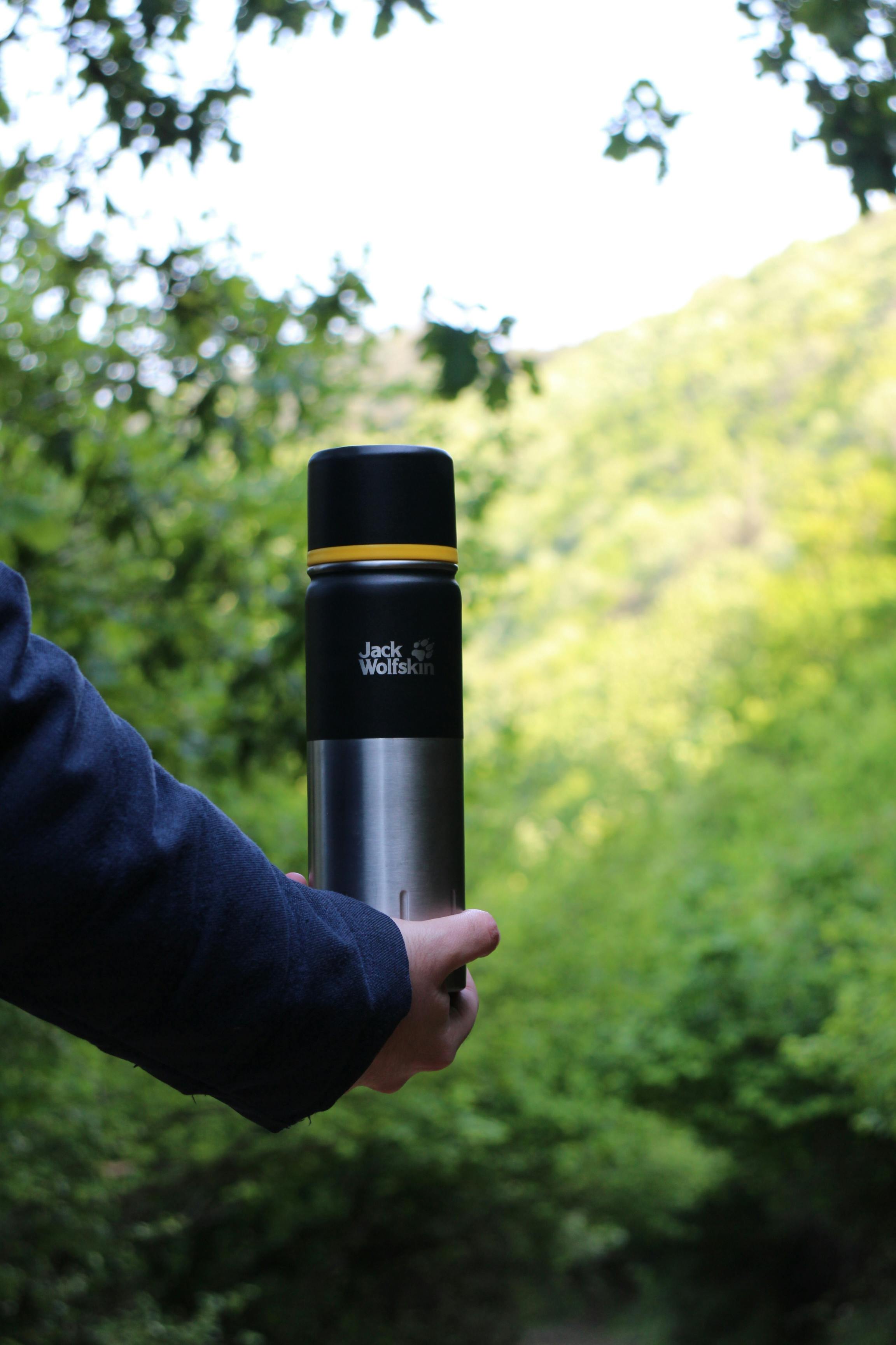 A Person Holding a Thermos Outdoors · Free Stock Photo