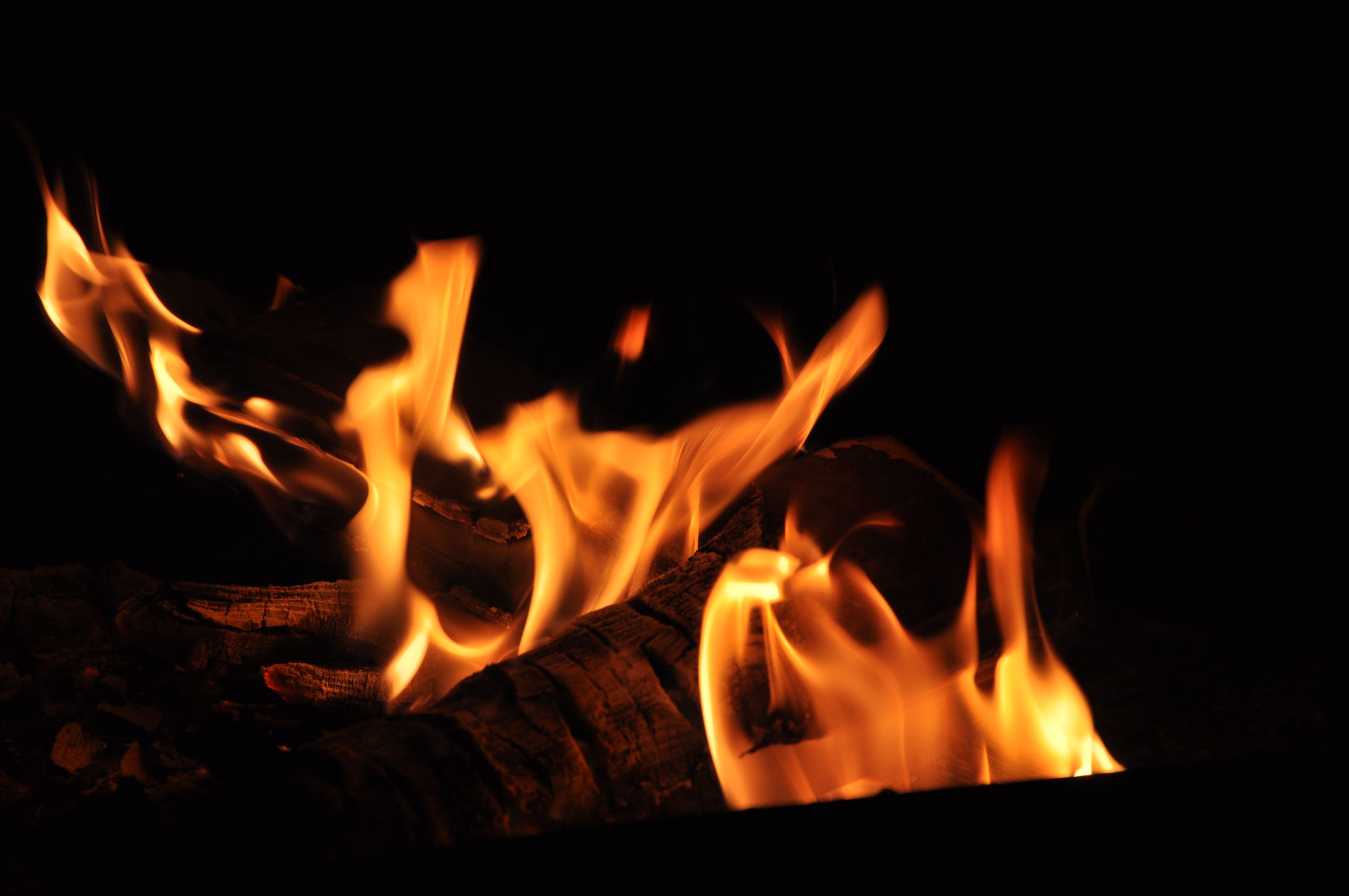 A fire is burning in the dark with some flames · Free Stock Photo