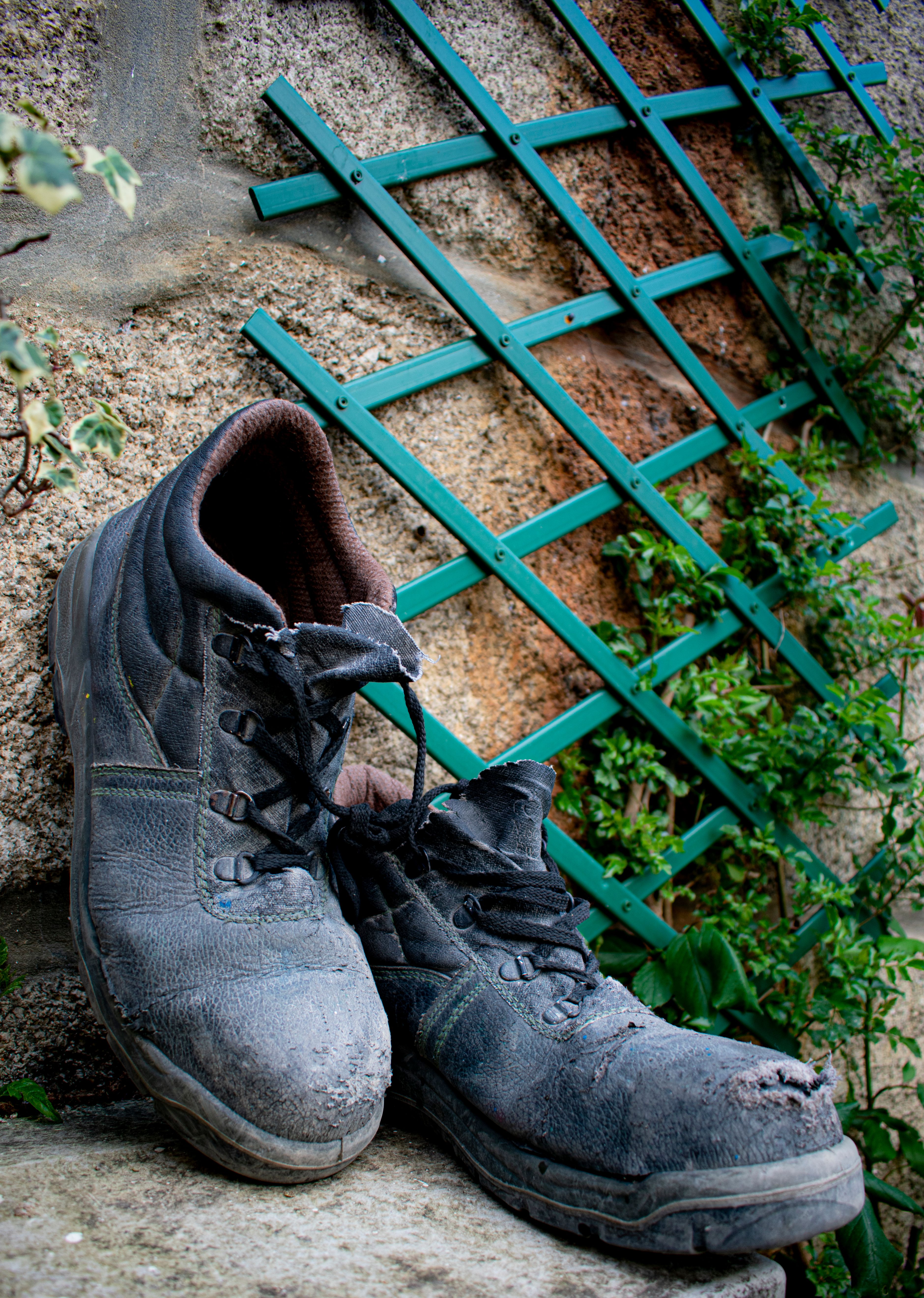 Black, Damaged Shoes on Ground · Free Stock Photo