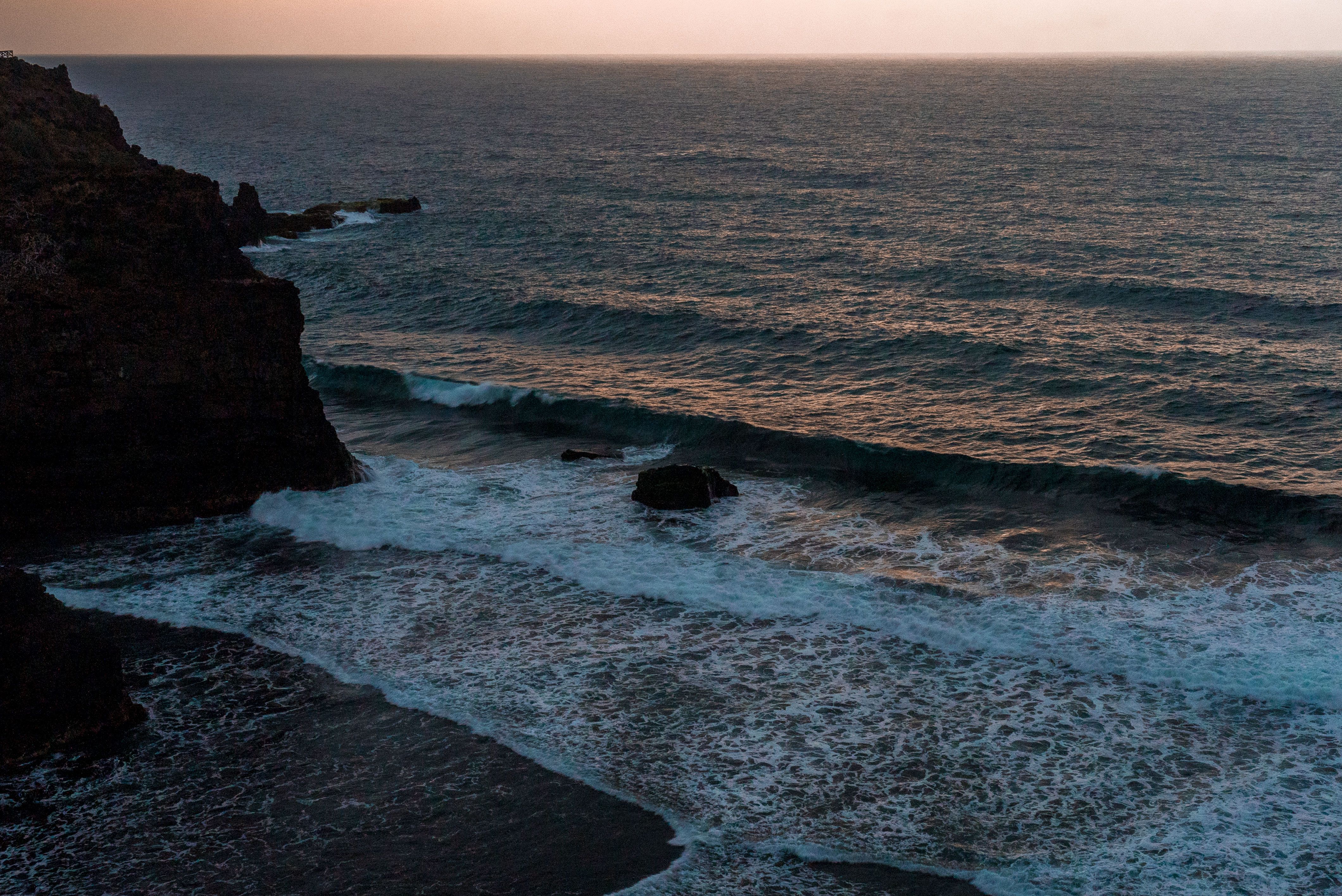 Surf Waves Rolling on a Rocky Sea Shore at Sunset · Free Stock Photo