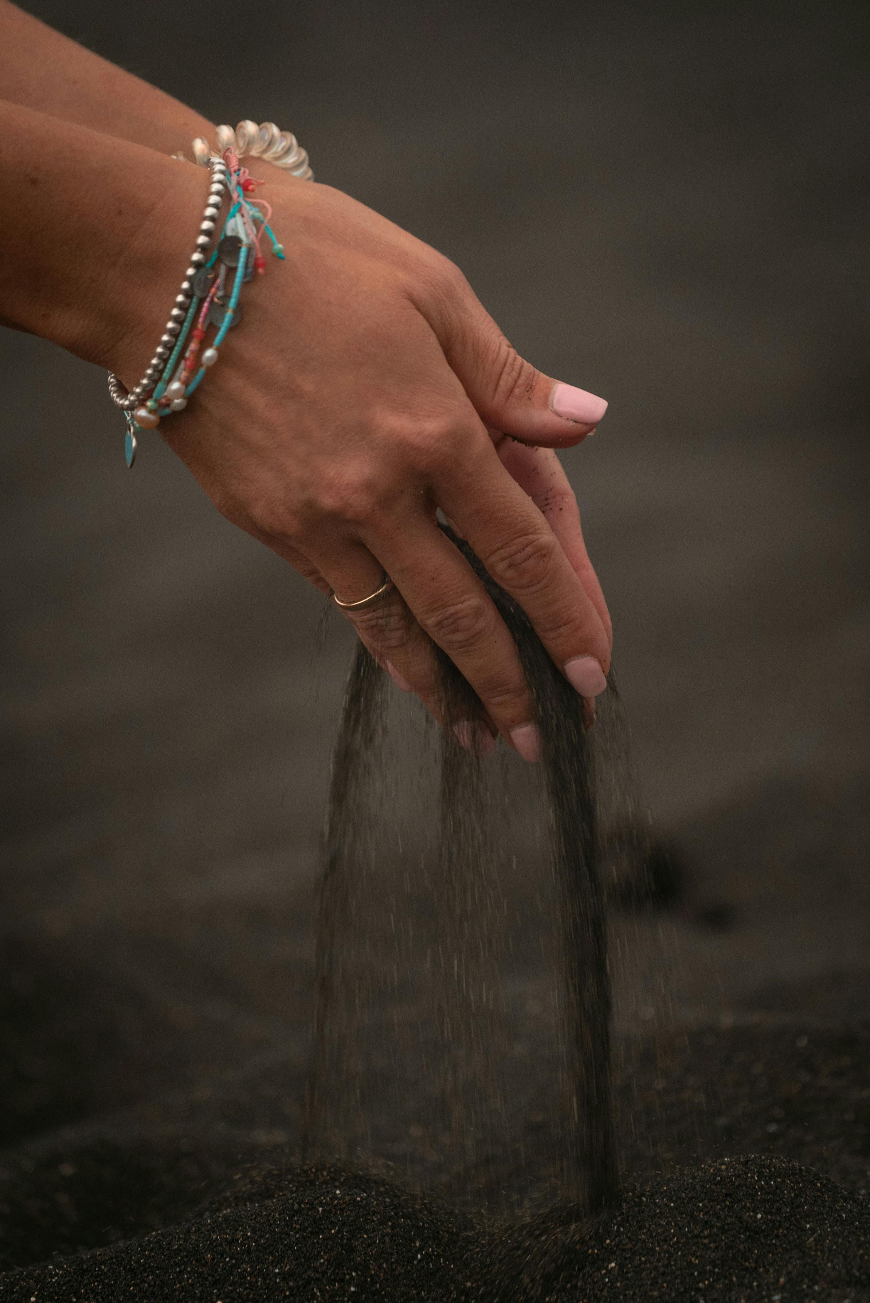Woman Spilling Sand through Hands · Free Stock Photo