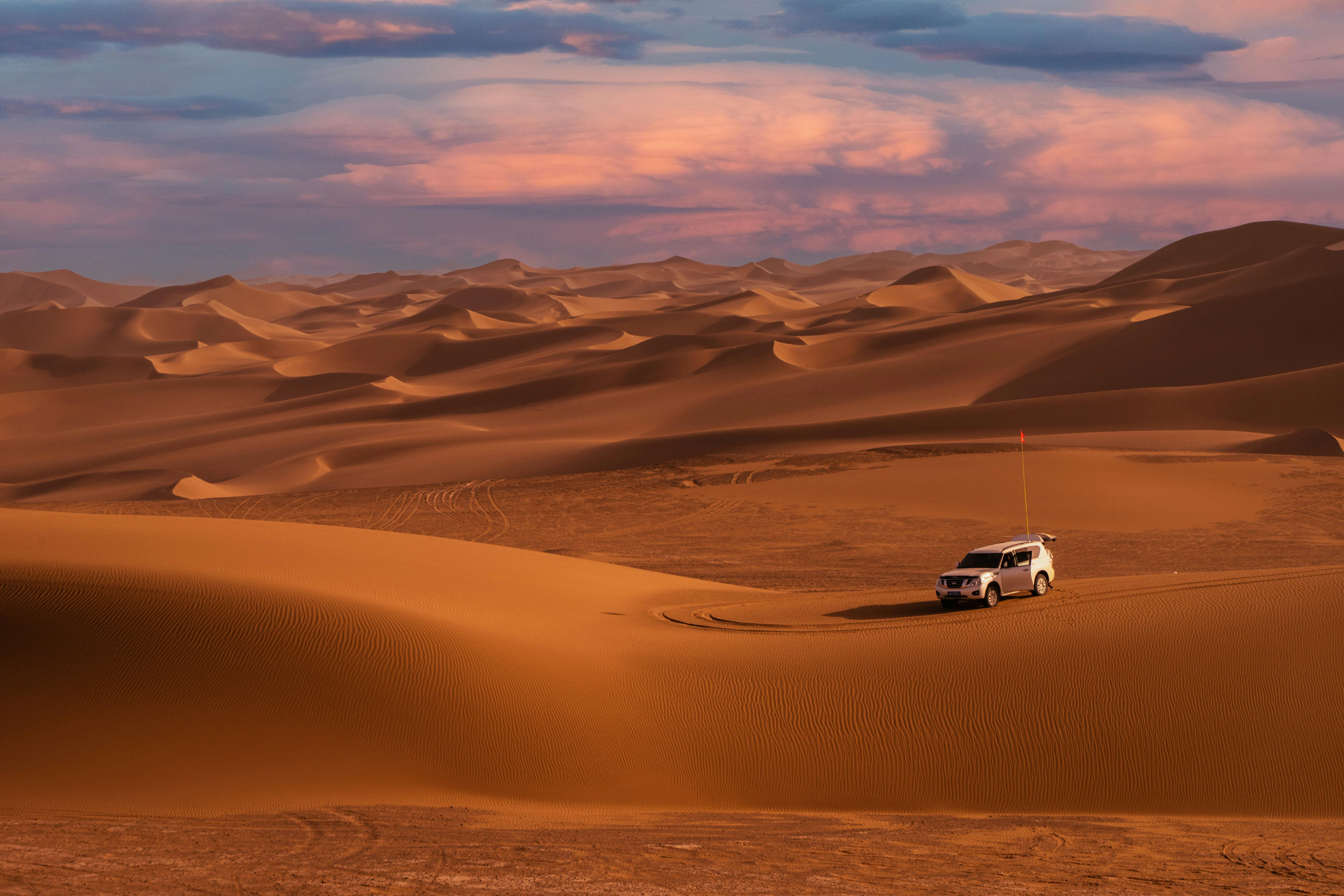 A Car on a Desert at Sunset · Free Stock Photo